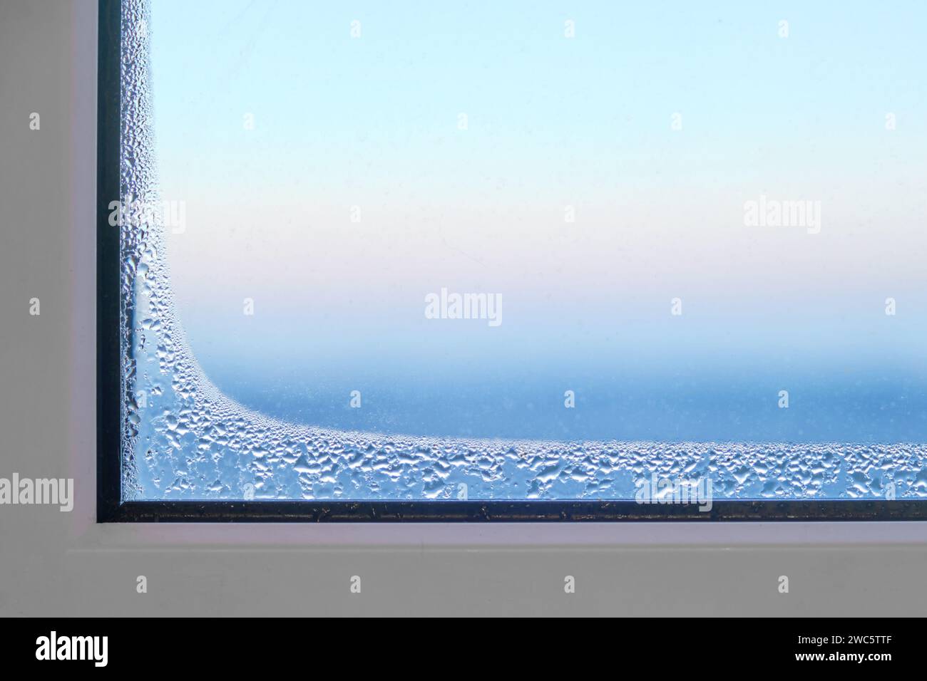 Foggy window glass covered with ice freezes indoors during severe ...