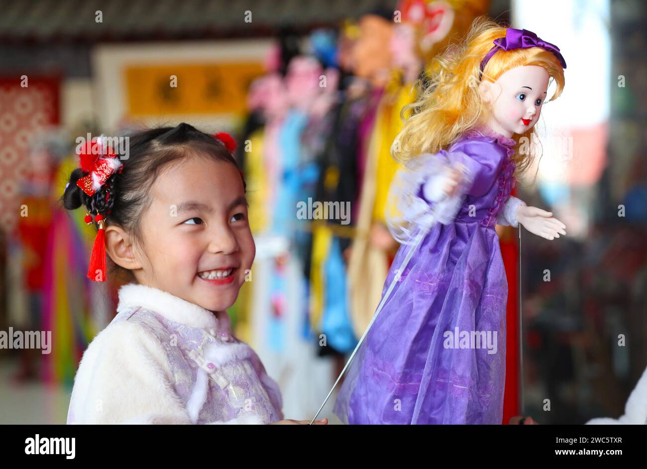 LAIXI, CHINA - JANUARY 14, 2024 - A child interacts with a puppet in ...