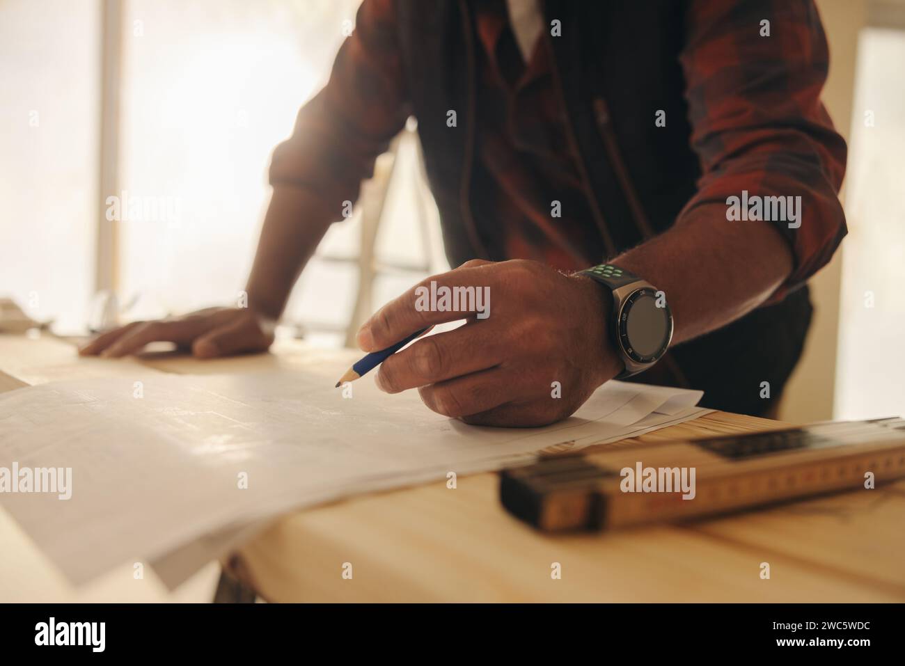 Contract worker marks blueprints with a pencil, demonstrating skill and ...