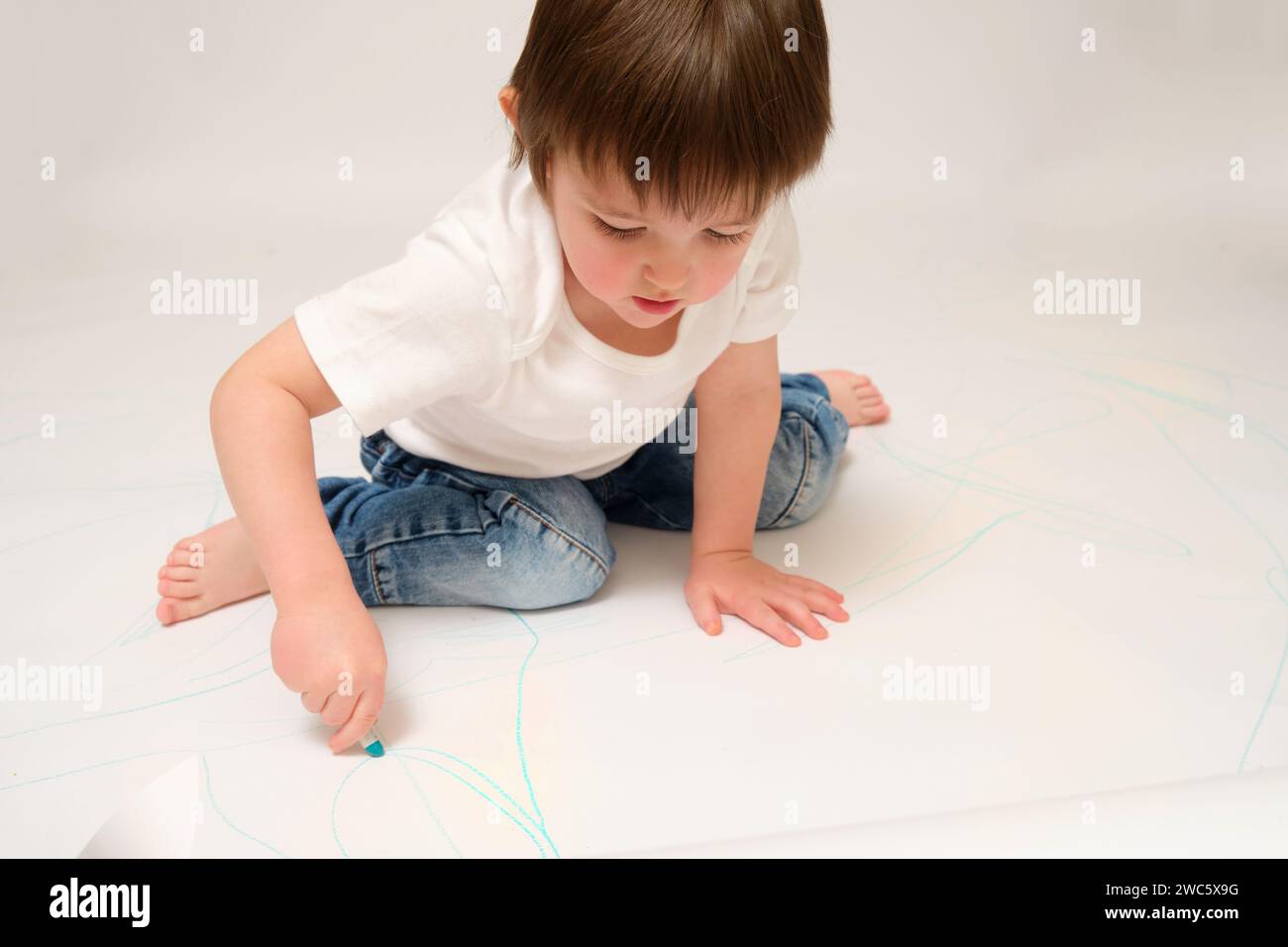 Toddler baby learn to draw on paper, studio white background. The child ...