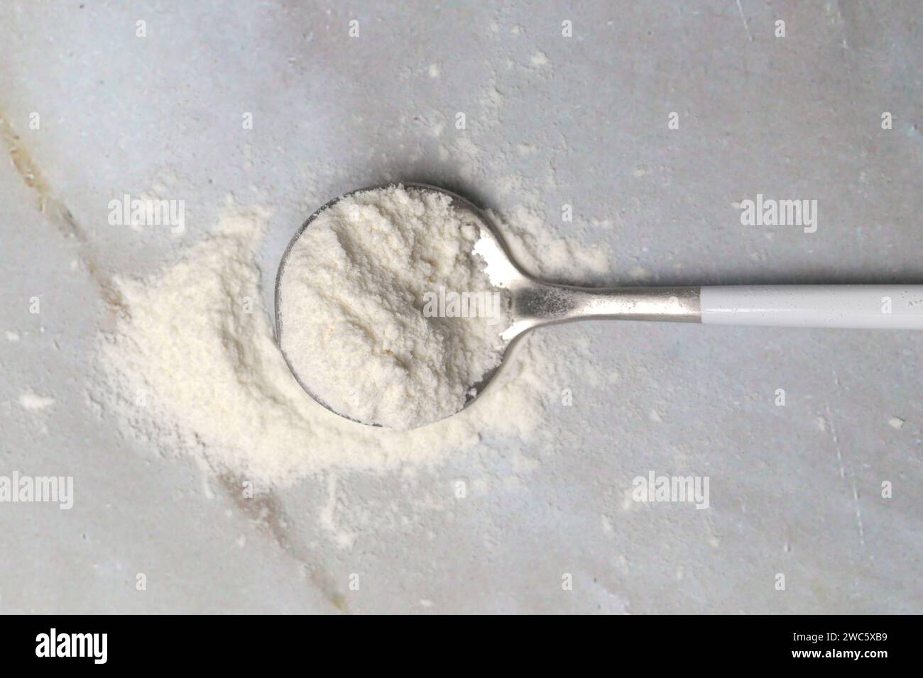 White powder in the spoon. Collagen protein powder or wheat flour ...