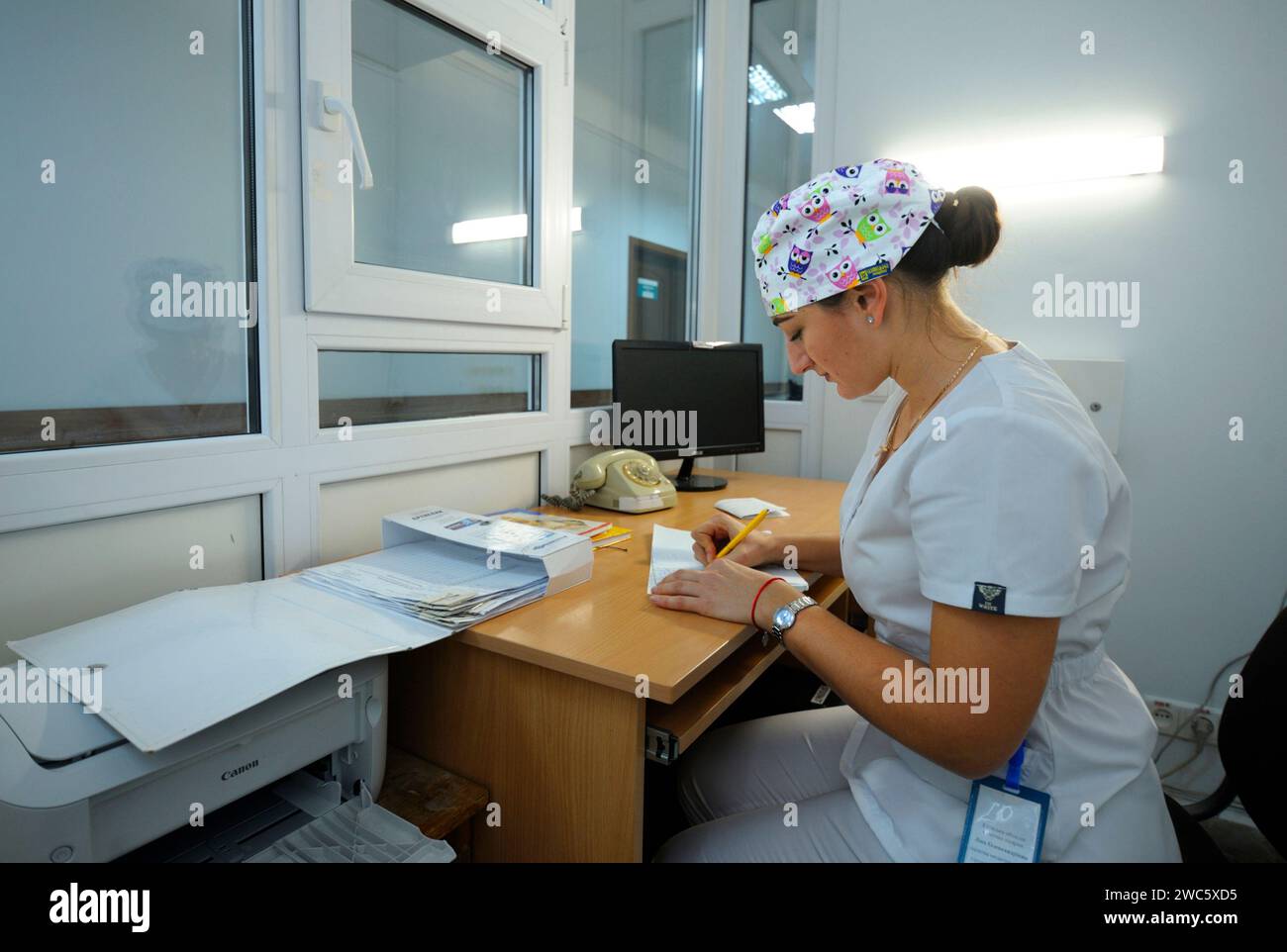On duty in a hospital. Nurse sitting at a nurse s station and writing ...
