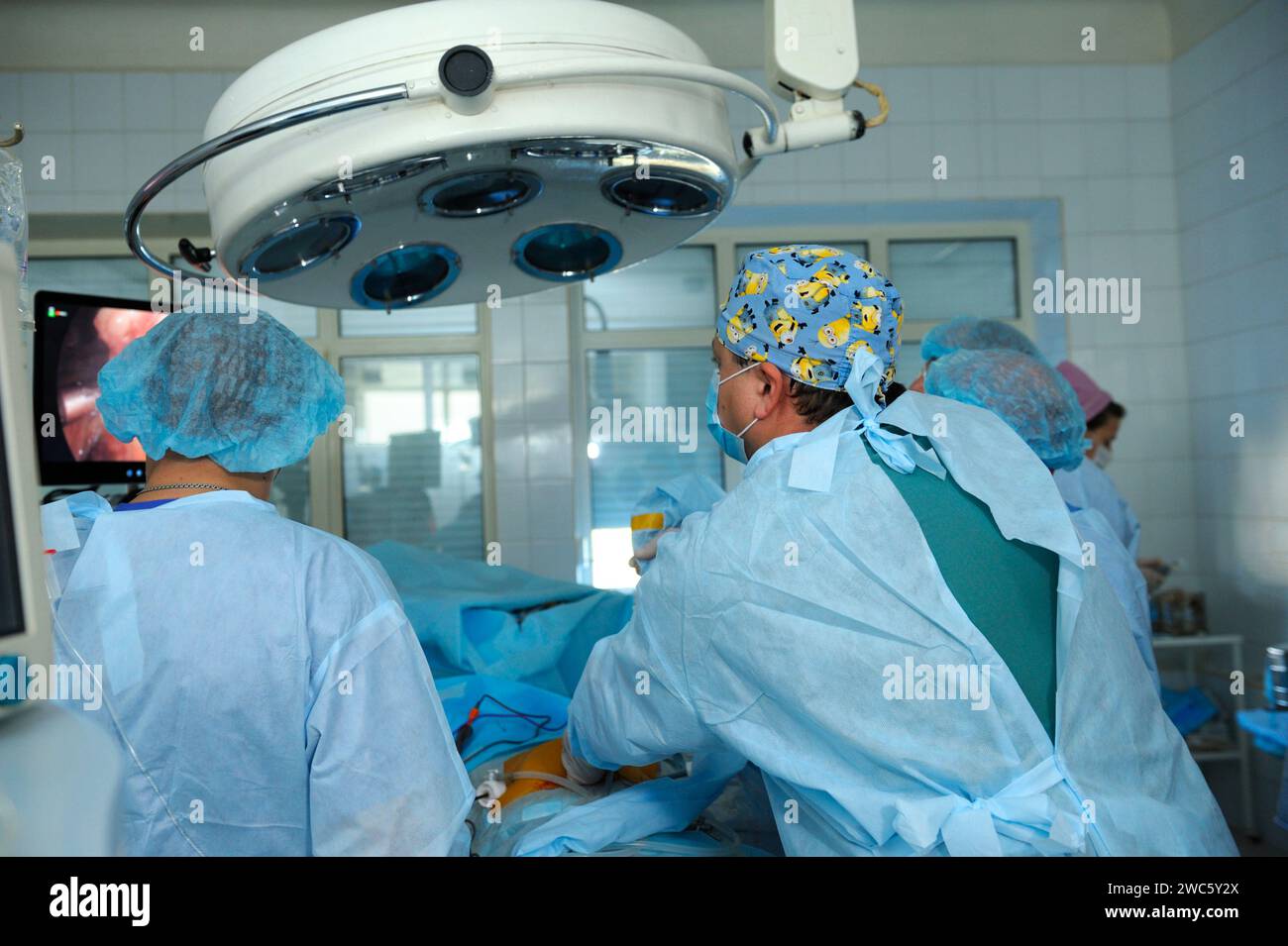 Laparoscopy surgery. Surgeons in face masks standing around patient ...