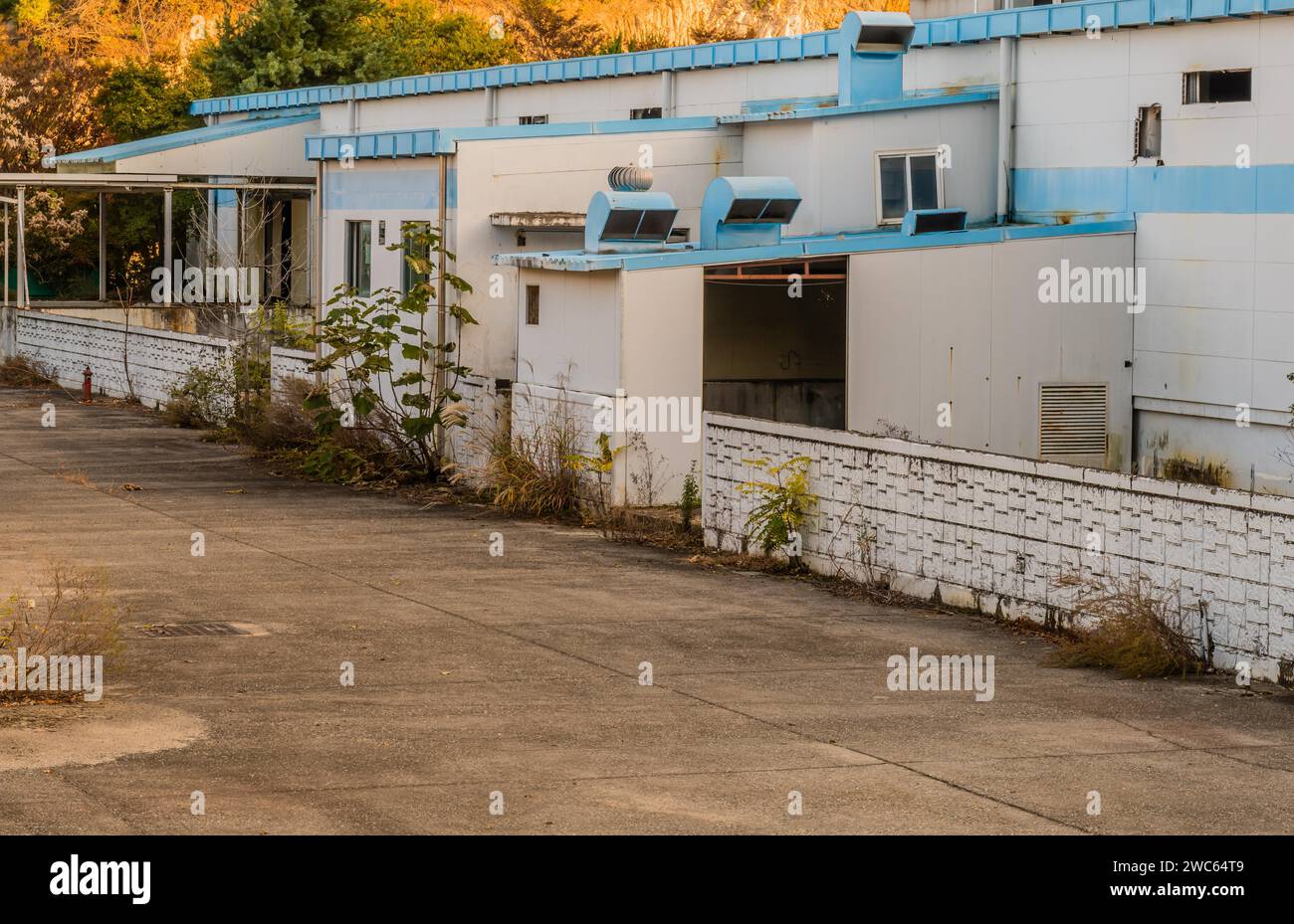 Exterior of old empty warehouse and parking lot in abandoned industrial ...