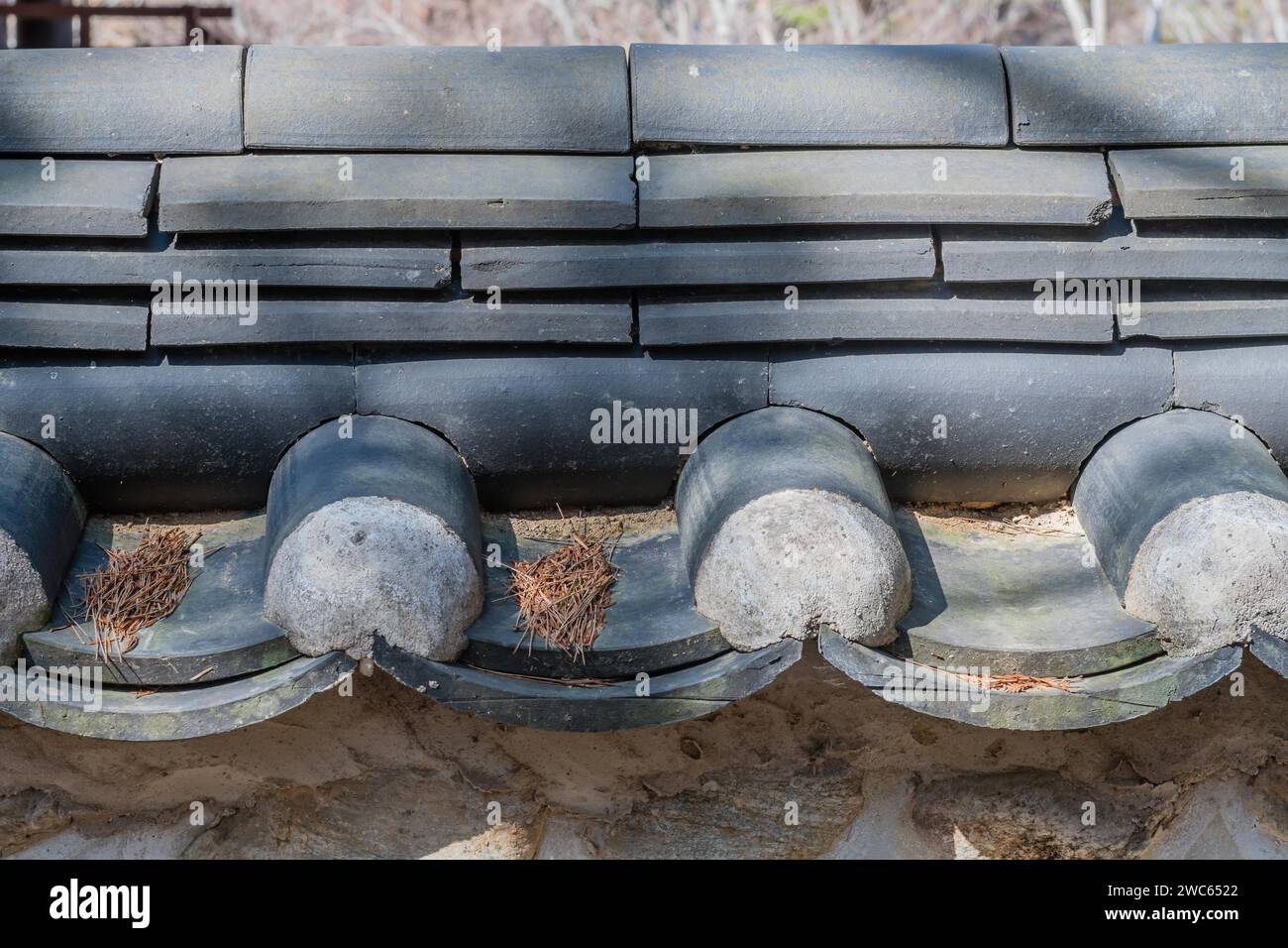 Closeup of ceramic tiles on top of mud and stone wall Stock Photo - Alamy