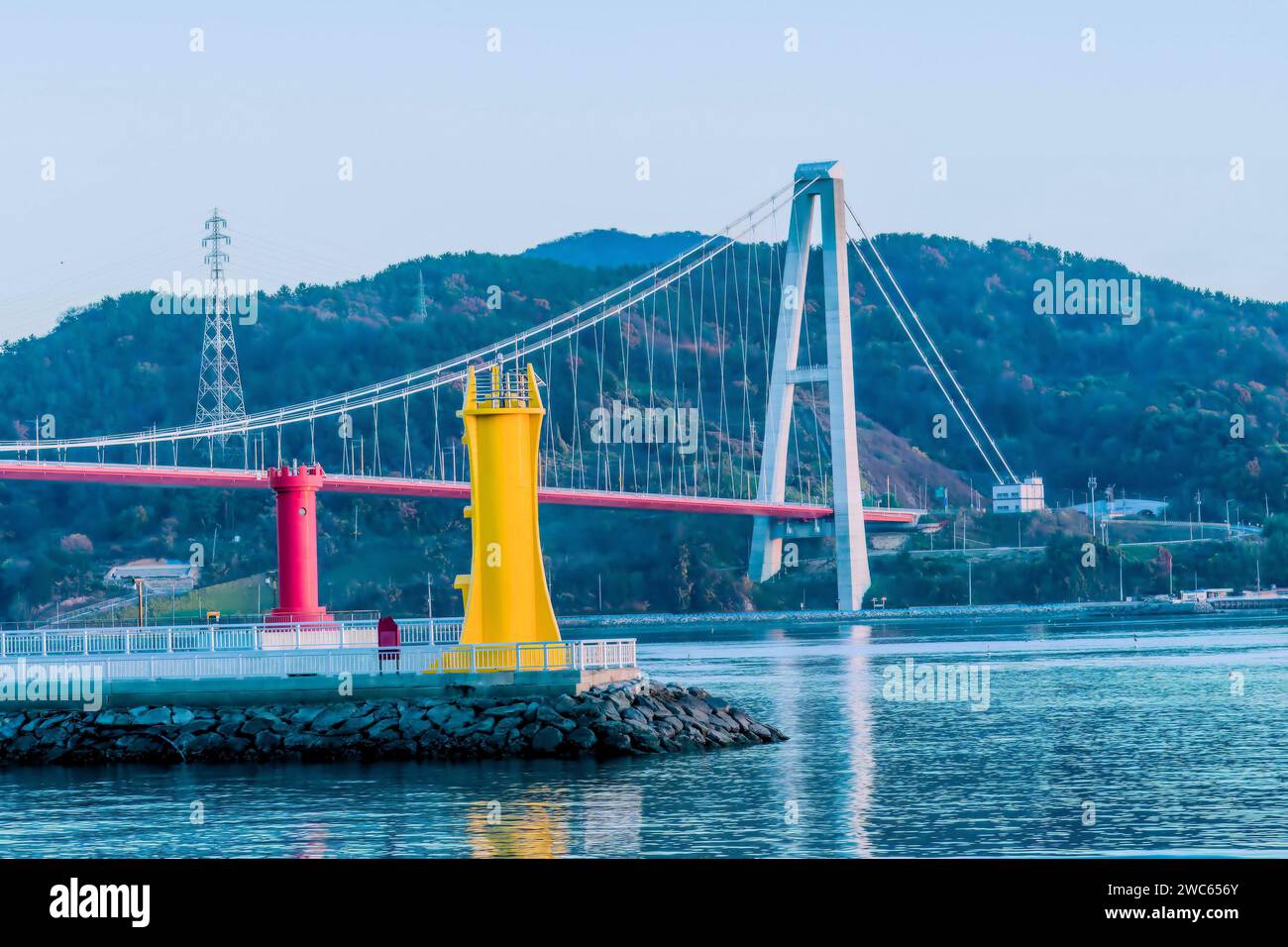 Two lighthouses at fishing port with suspension bridge in background ...