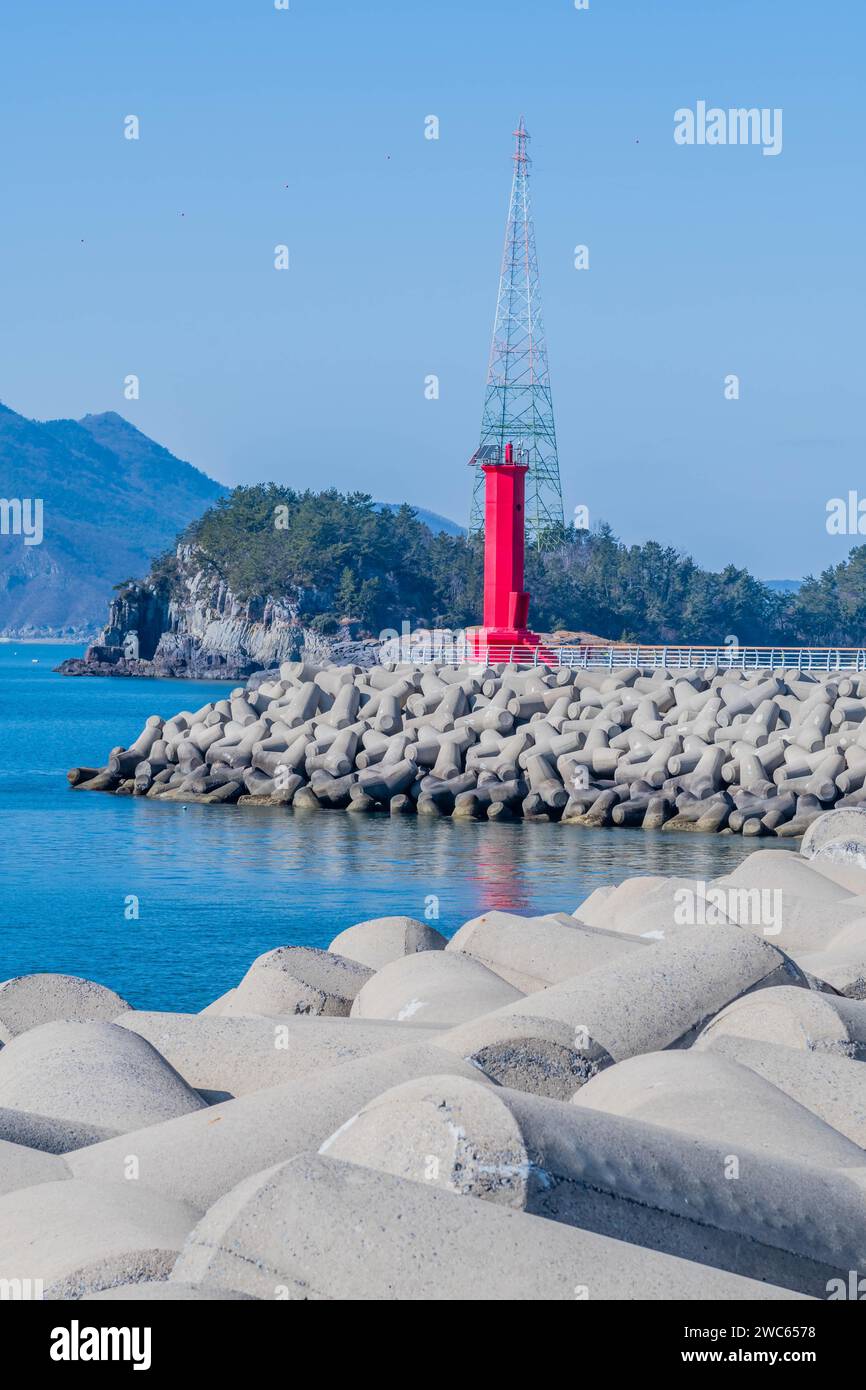 Red lighthouse on concrete pier in small coastal fishing port Stock ...