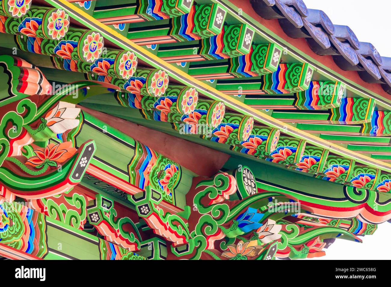 Eve of a Buddhist temple building with vibrant green, red, blue, and ...