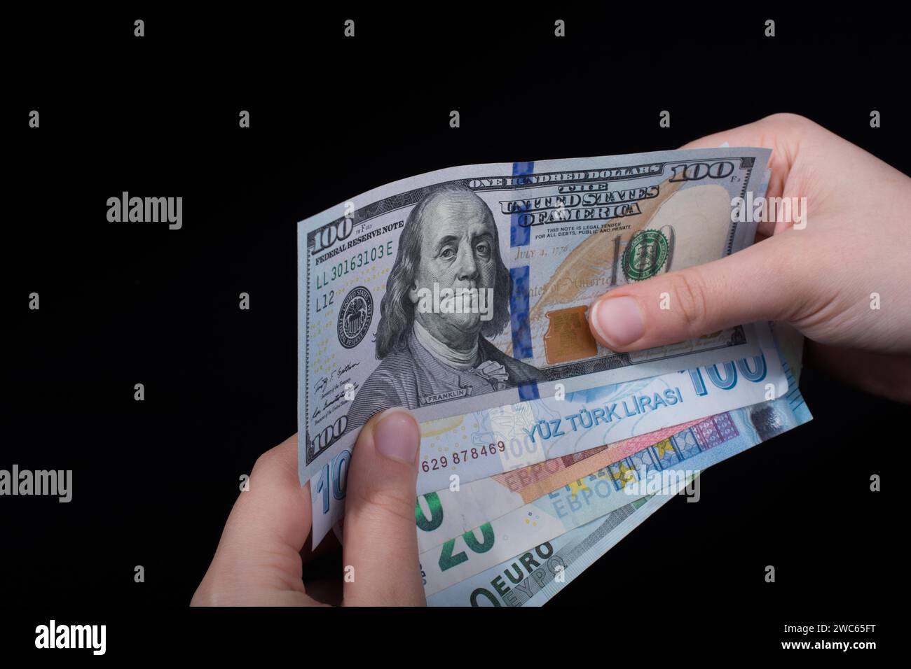 Hand holding American dollar banknotes isolated on black background ...