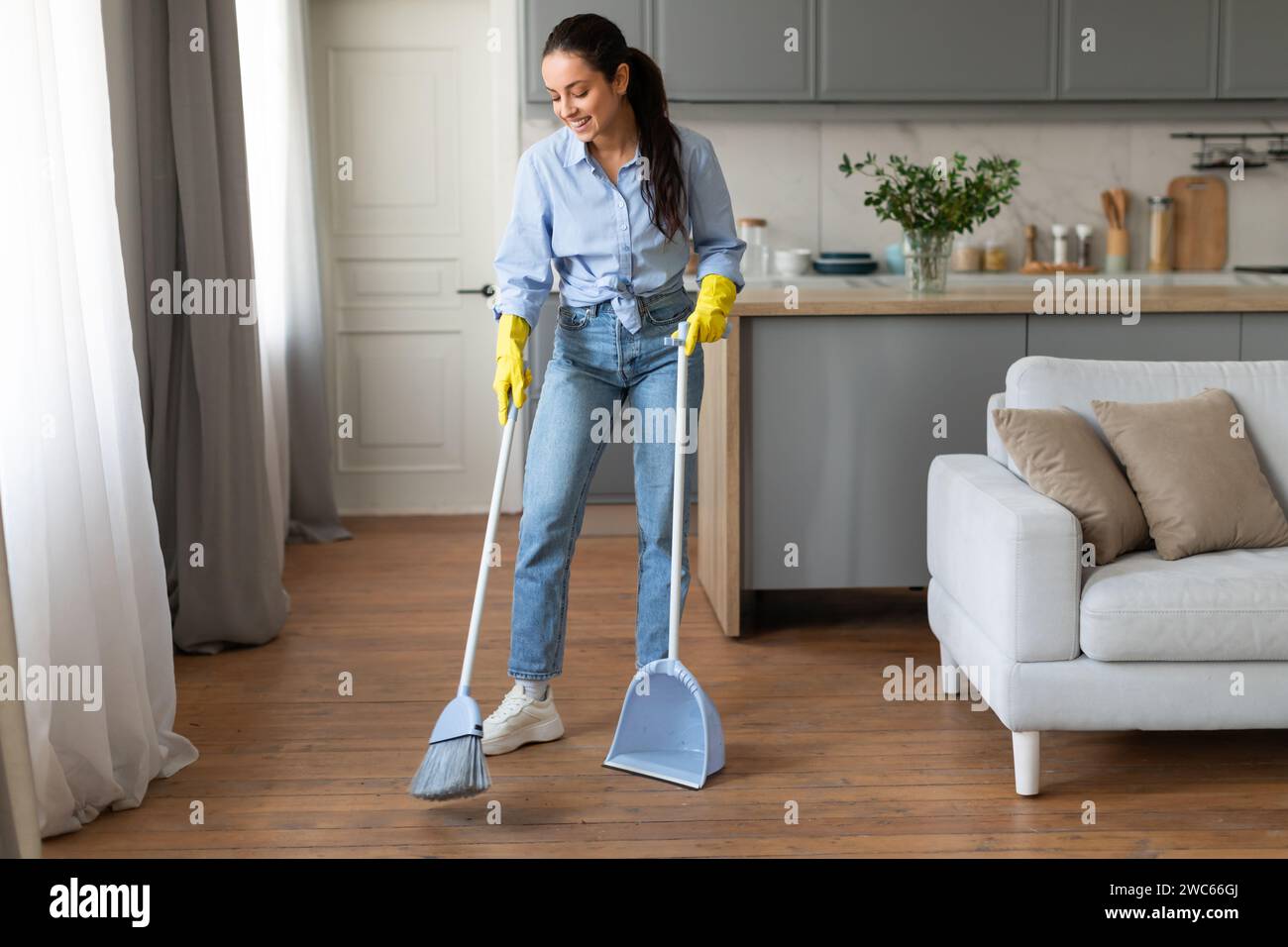 Woman with broom and dustpan cleaning the wooden floor Stock Photo - Alamy