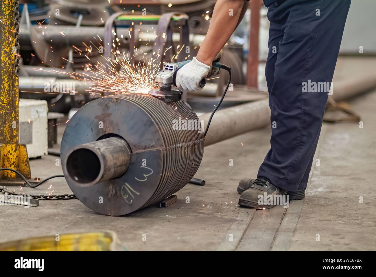 Industrial worker using an angle grinder at the early stages of making ...