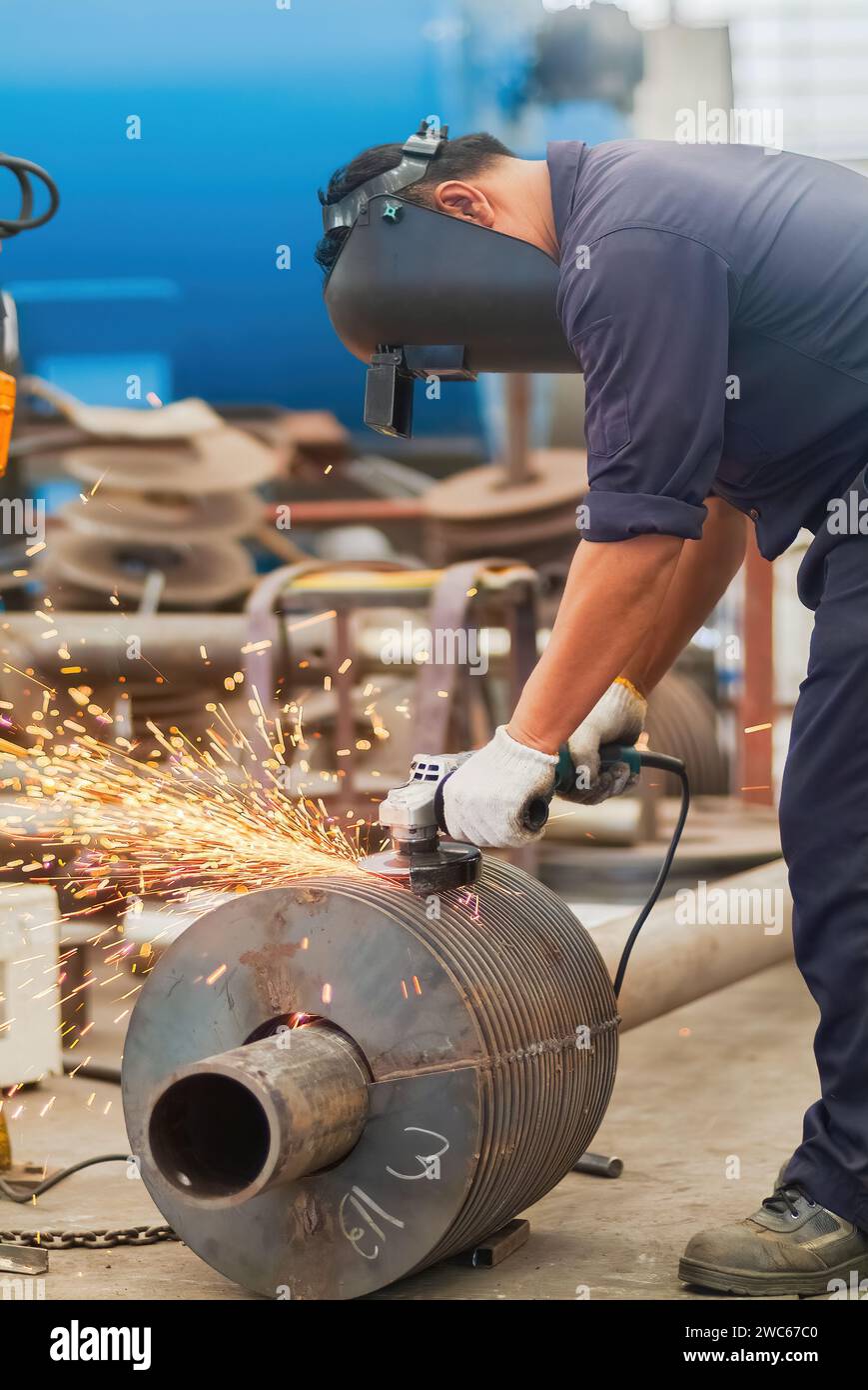 Industrial worker using an angle grinder at the early stages of making ...