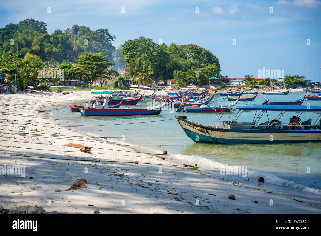 Fishing boats on the sea and beach of George Town city in the distance ...