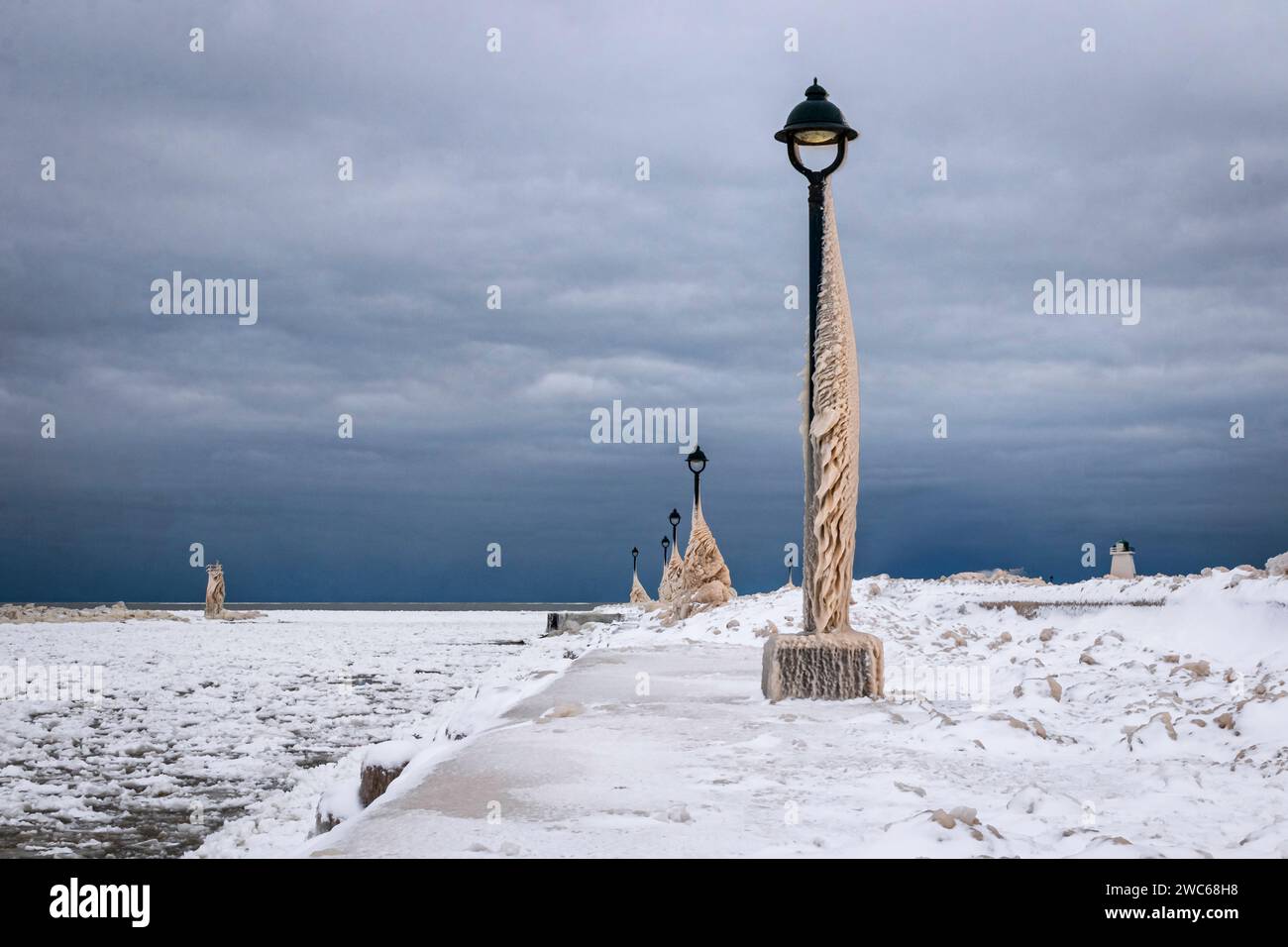 Lake Erie pier in Ontario, Canada, light posts covered in ice. Natural ...