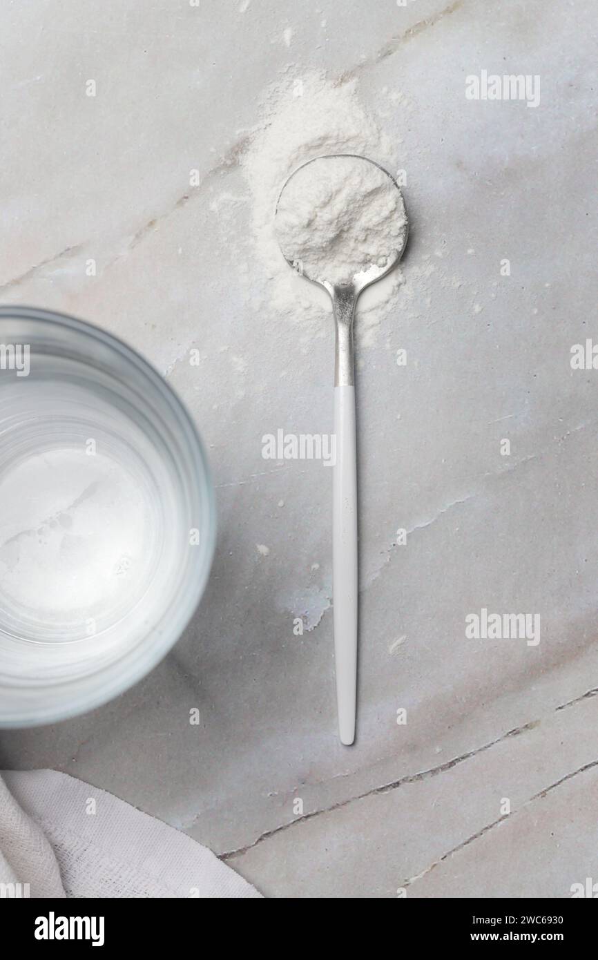 White powder in the spoon. Collagen protein powder or wheat flour ...