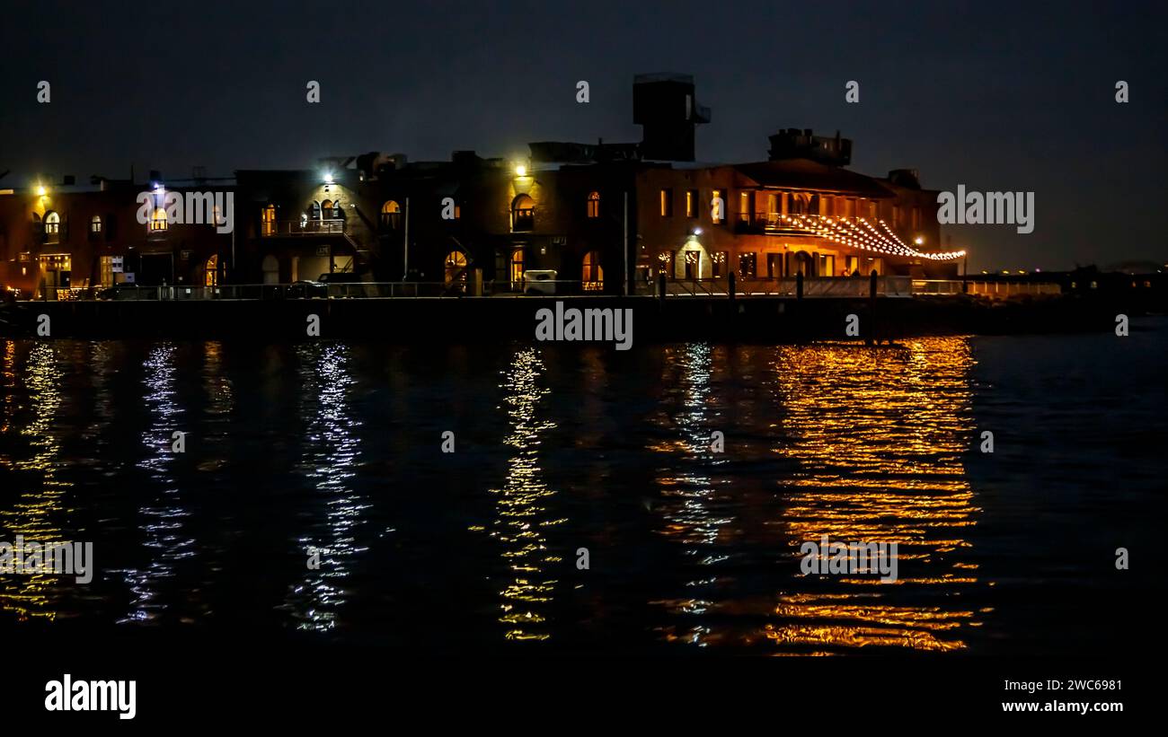 Red Hook old pier buildings with night lights and reflection in water ...