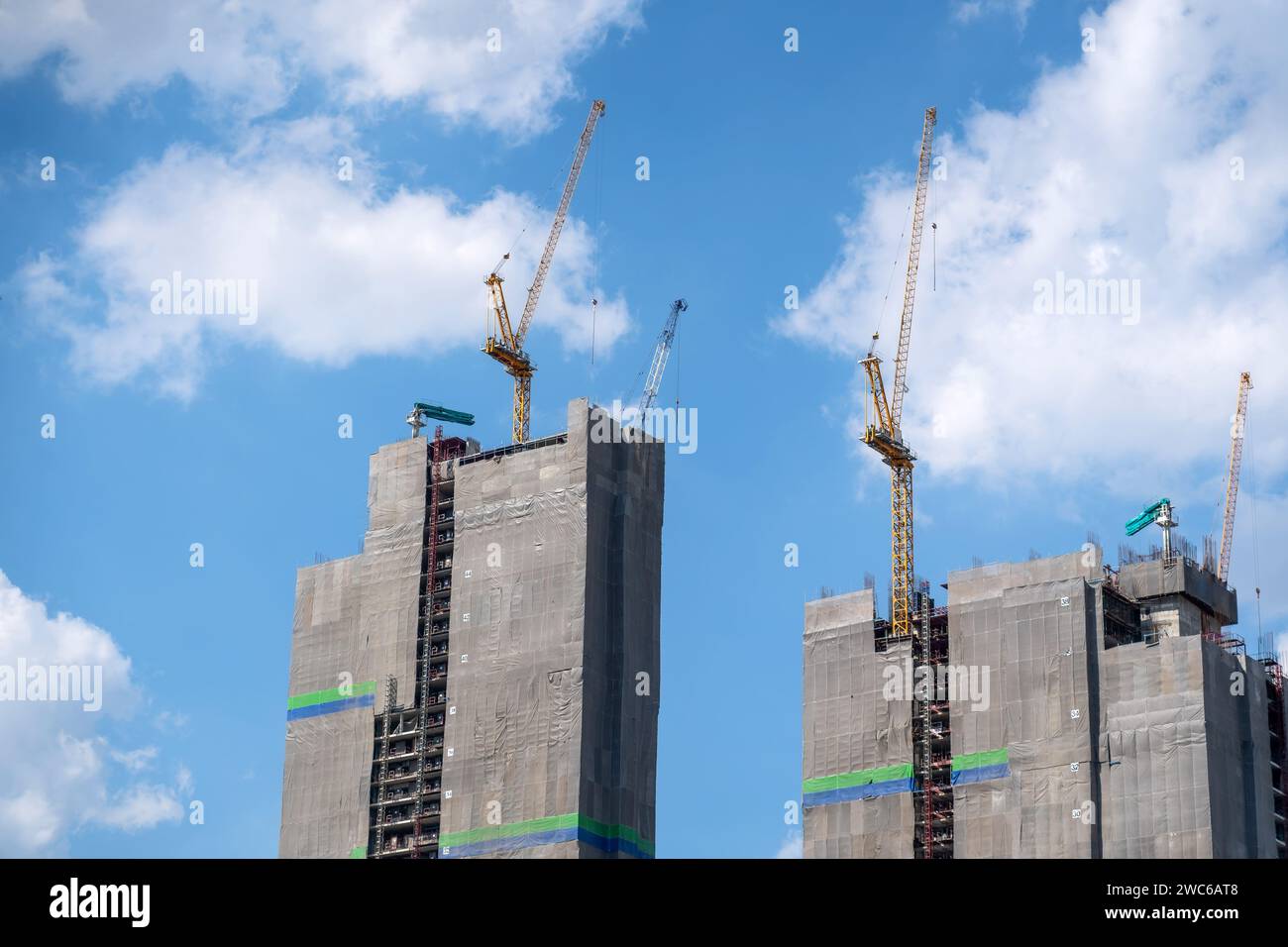 Two standing high-rise towers in the scaffolding are covered with ...