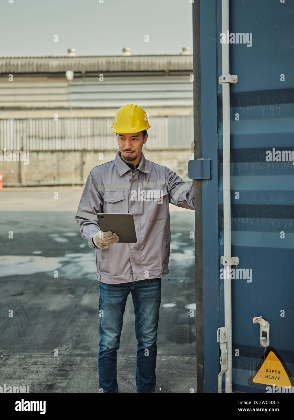 The male Industrial Supervisor with Tablet Managing the Process Loading ...
