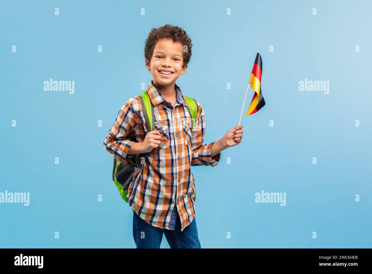 Smiling boy with German flag, plaid shirt on blue background Stock ...