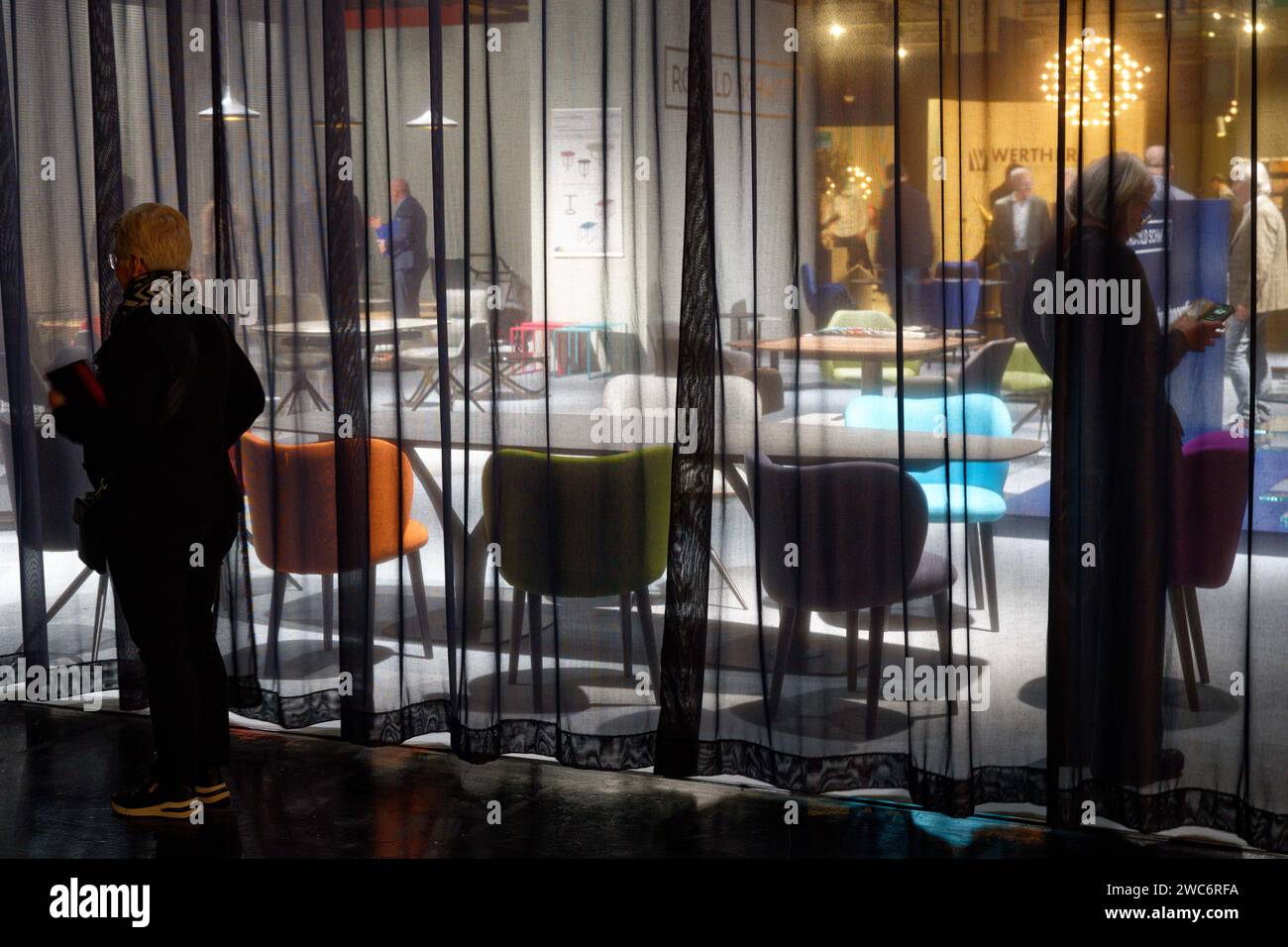 14 January 2024, North Rhine-Westphalia, Cologne: Visitors walk past the exhibitors' stands at ...