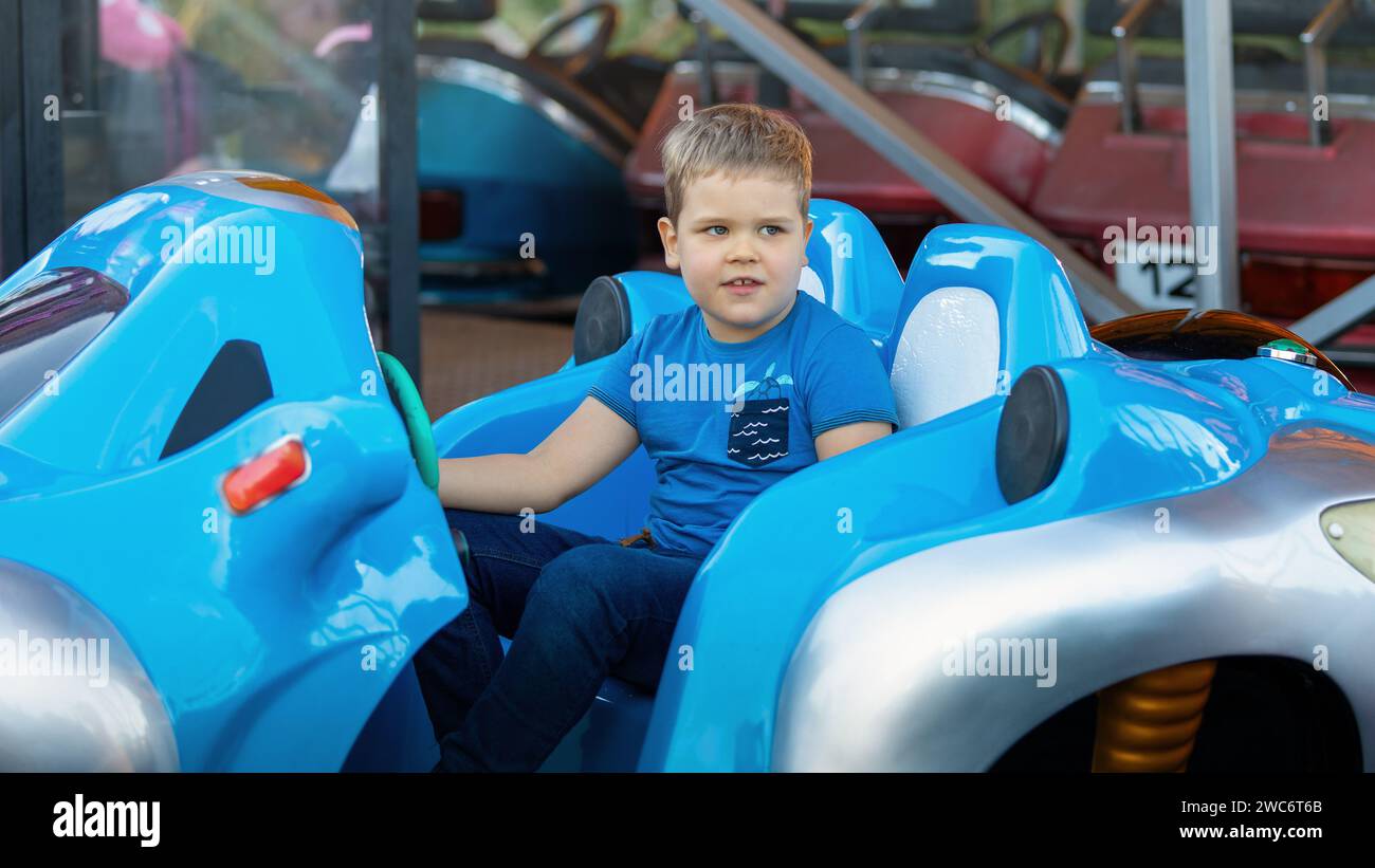 Little boy having fun riding big blue bumper car Stock Photo - Alamy
