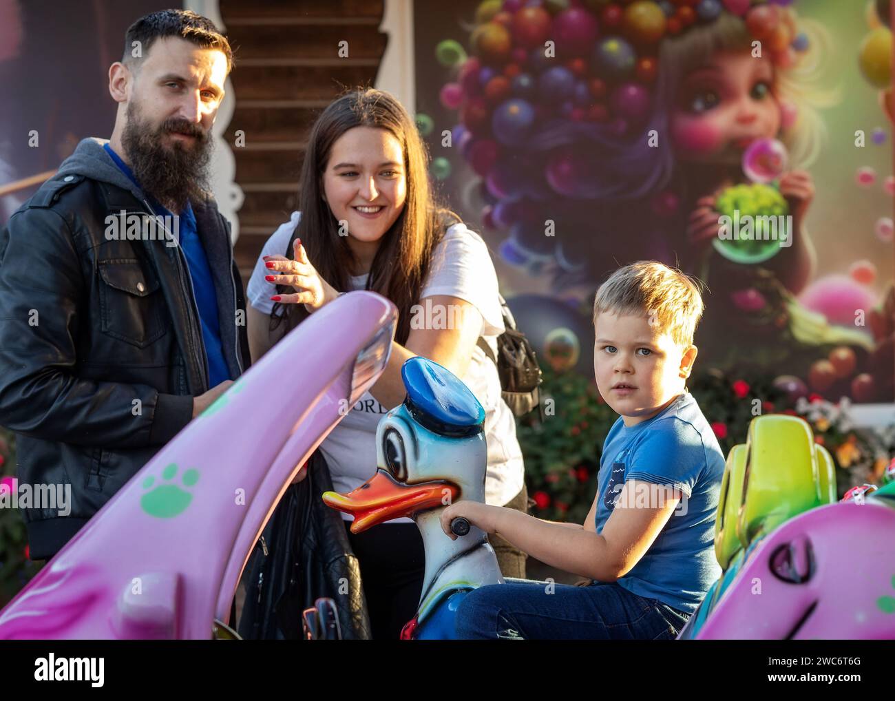 Beautiful boy having fun on the ride at the local carnival on the duck ...