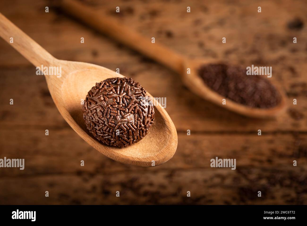 Chocolate brigadeiro in wooden spoon. Brigadeiro, traditional Brazilian ...