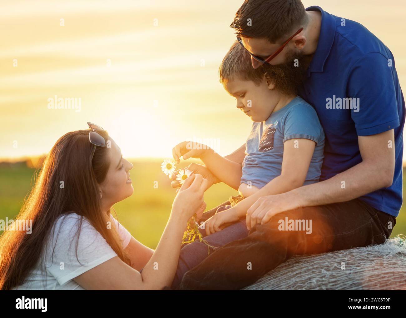 Portrait of a beautiful young family against the background of a summer ...
