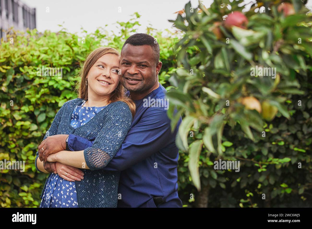 Tilst, Denmark, 12th of August: Interracial family hugging in backyard ...