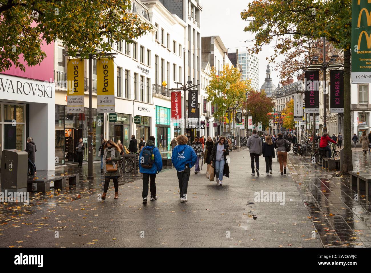 On a rainy day in autumn, people walk through the popular shopping ...