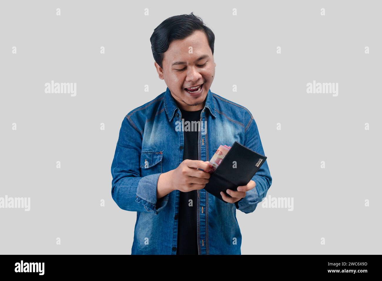 Young Asian man showing happy face expression while holding his wallet ...