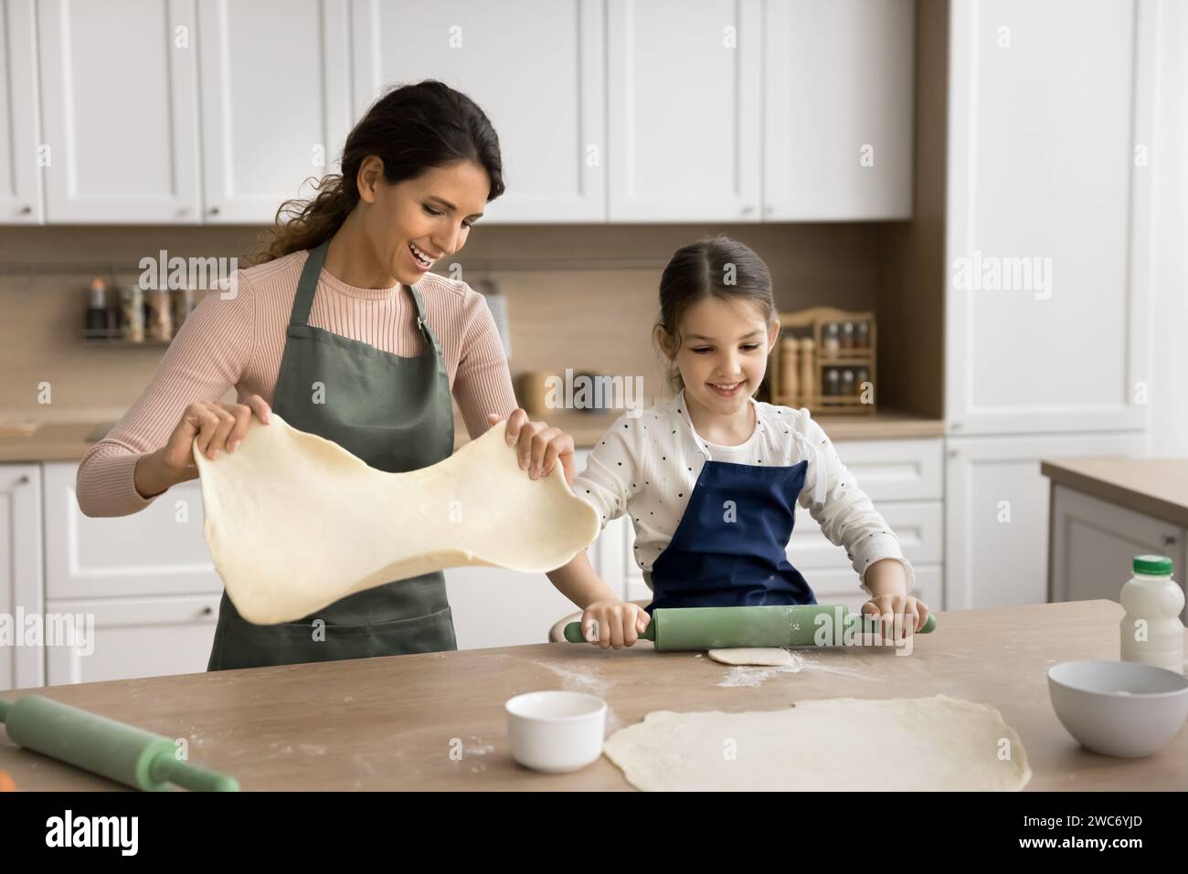 Happy kid girl helping mom to bake, preparing homemade pies Stock Photo ...