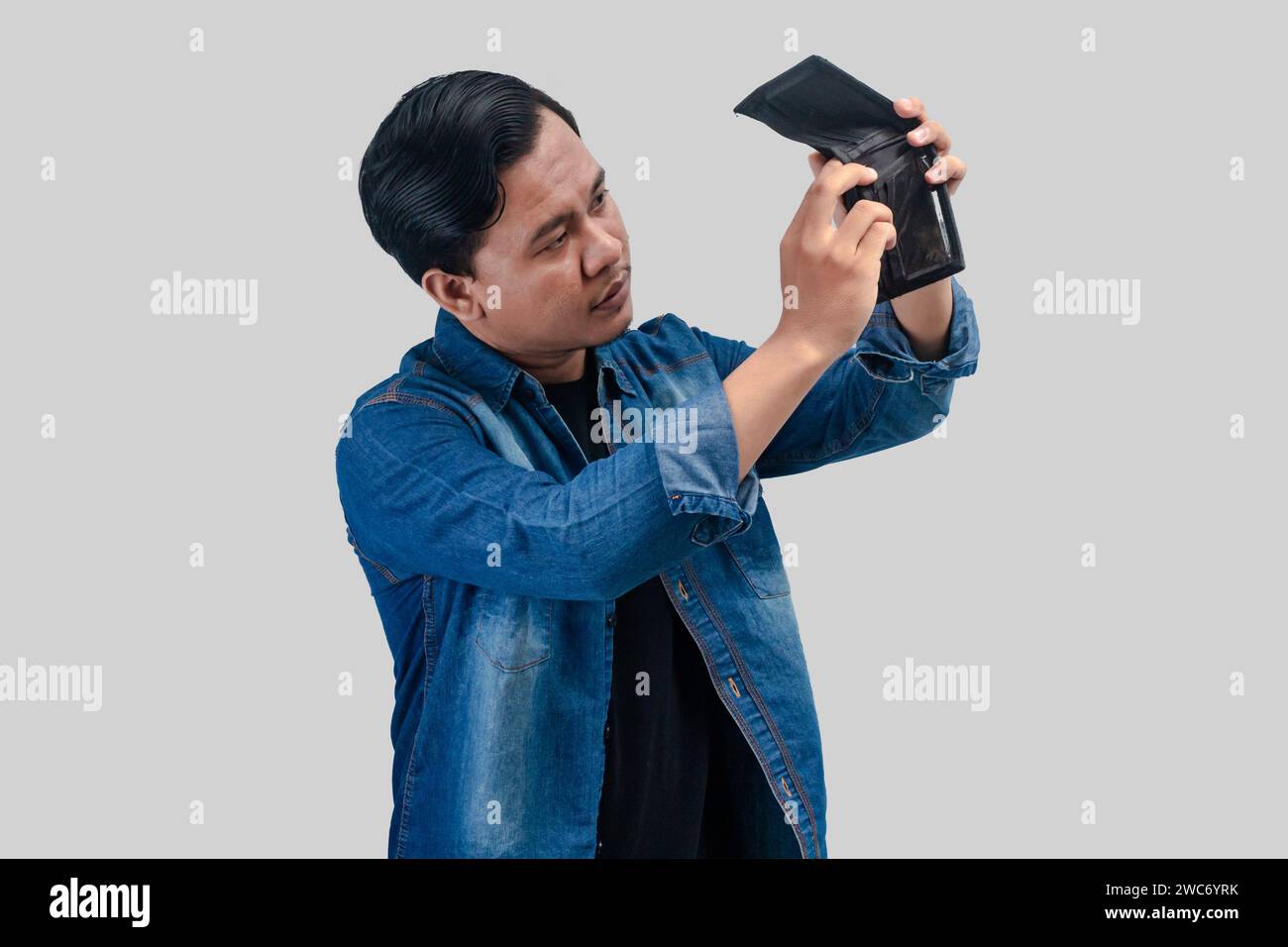 Young Asian man showing sad face expression while holding his empty ...