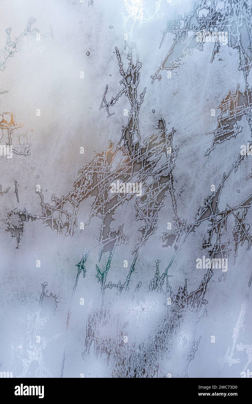 window glass covered with ice and frost. ice pattern on glass. vertical ...