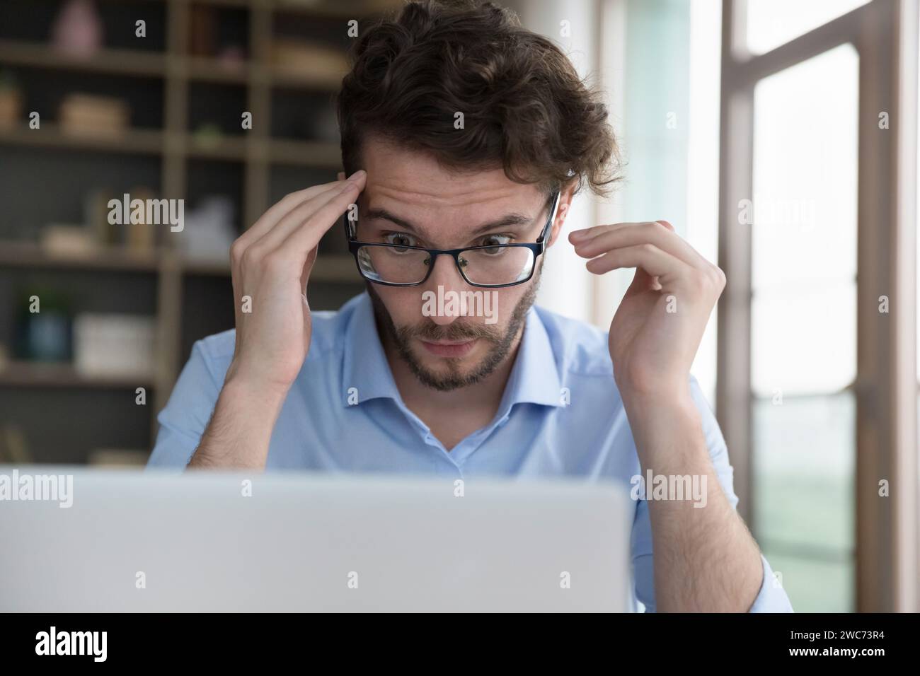Man in glasses stare wide-eyed at laptop screen Stock Photo - Alamy