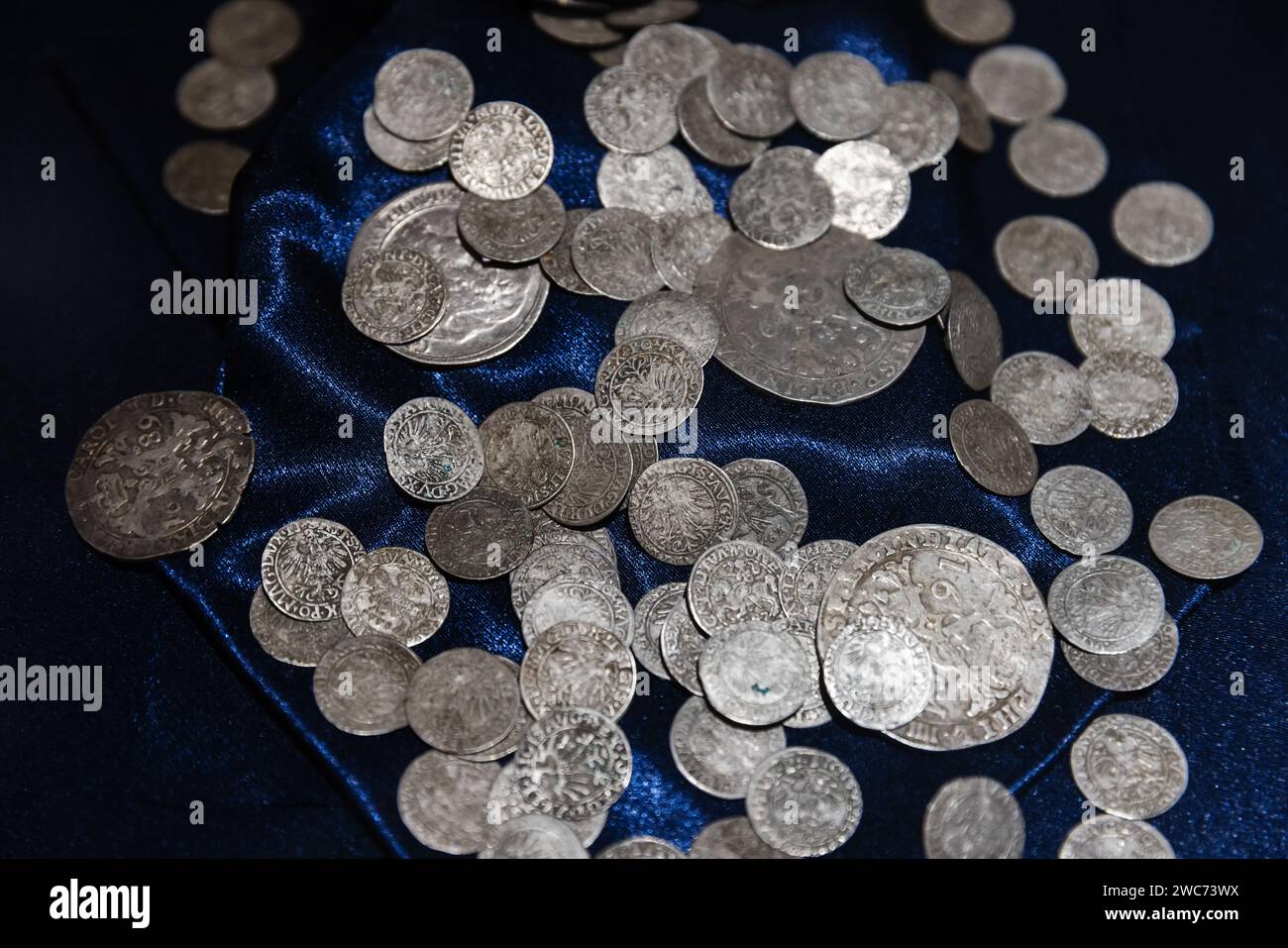 Ancient silver coins lay on deep blue silk, close up photo with ...