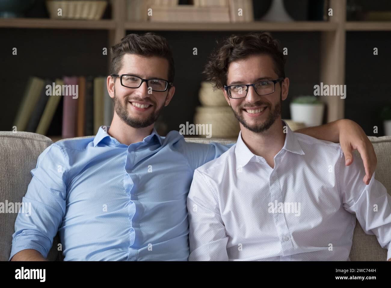 Millennial twins brothers smiling, looking at camera posing indoors ...