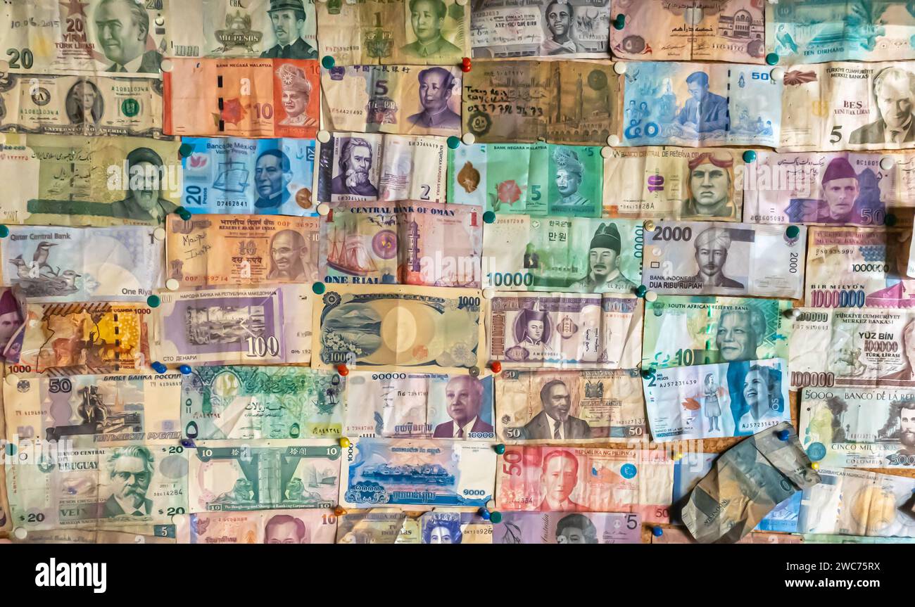 Collection of banknotes from different countries on the wall at ...