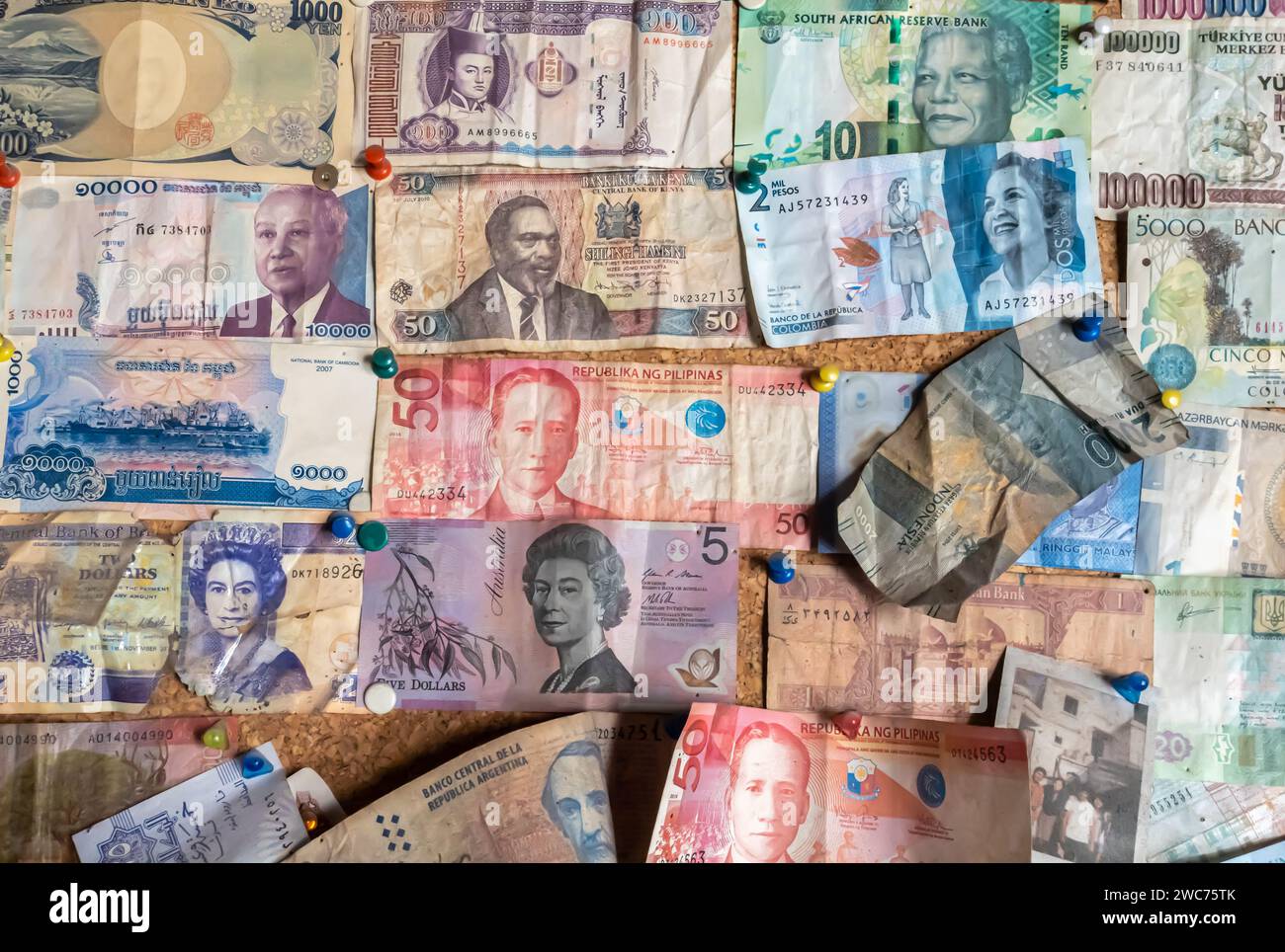 Collection of banknotes from different countries on the wall at ...