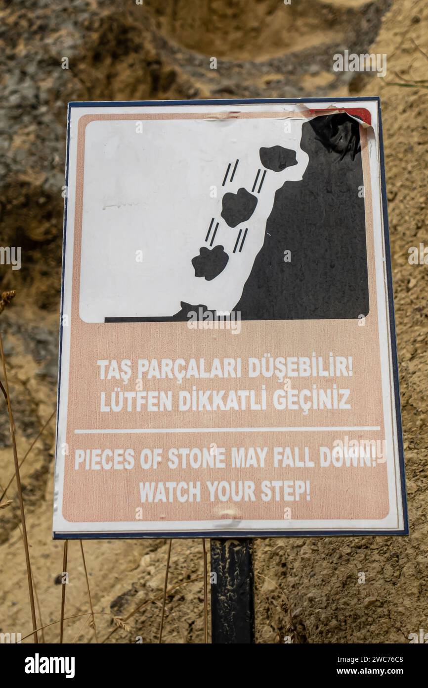 Warning sign "Pieces of stone may fall down watch your step" bilingual ...