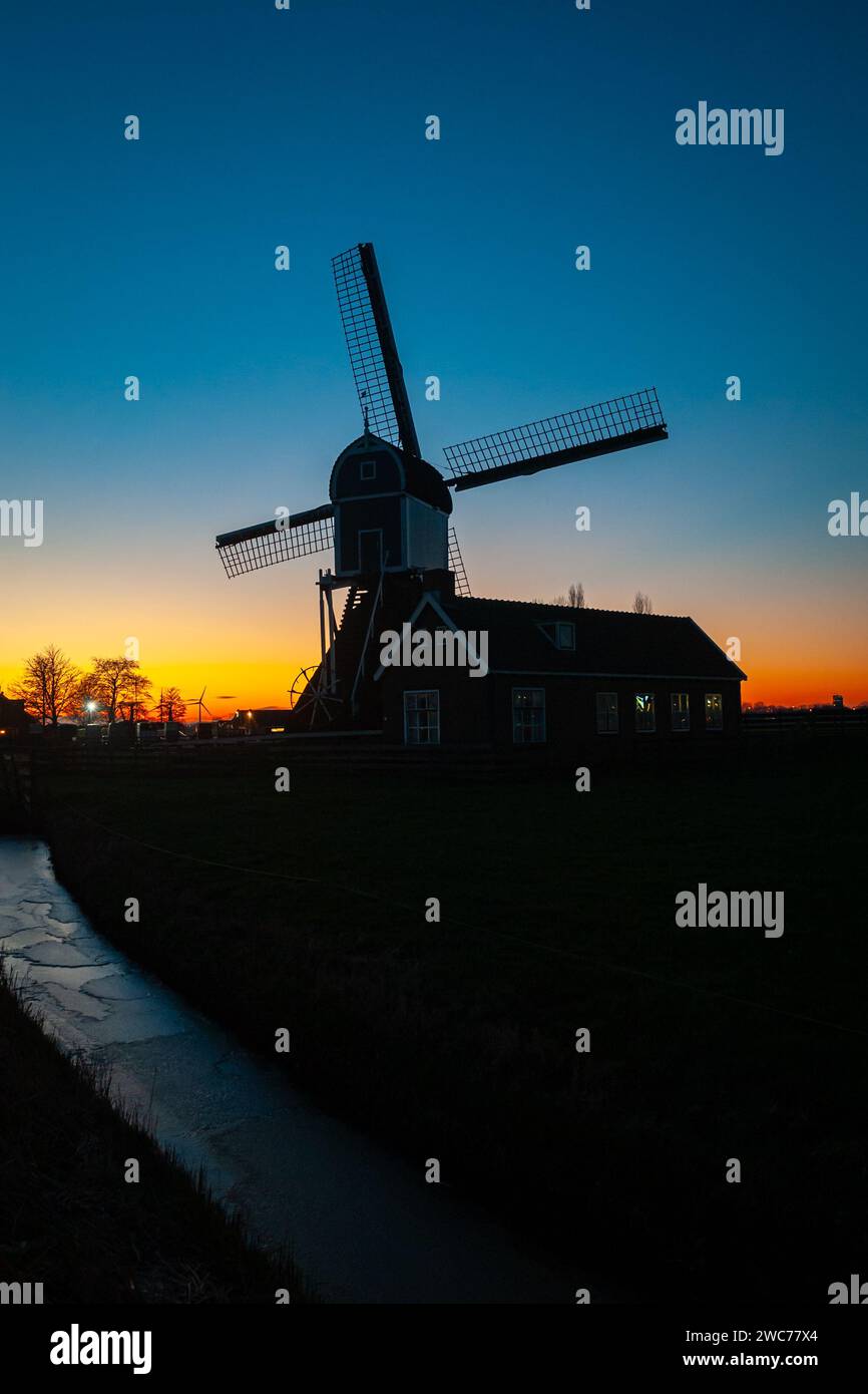 Traditional Dutch windmill in Zoeterwoude, Holland stands out against a ...