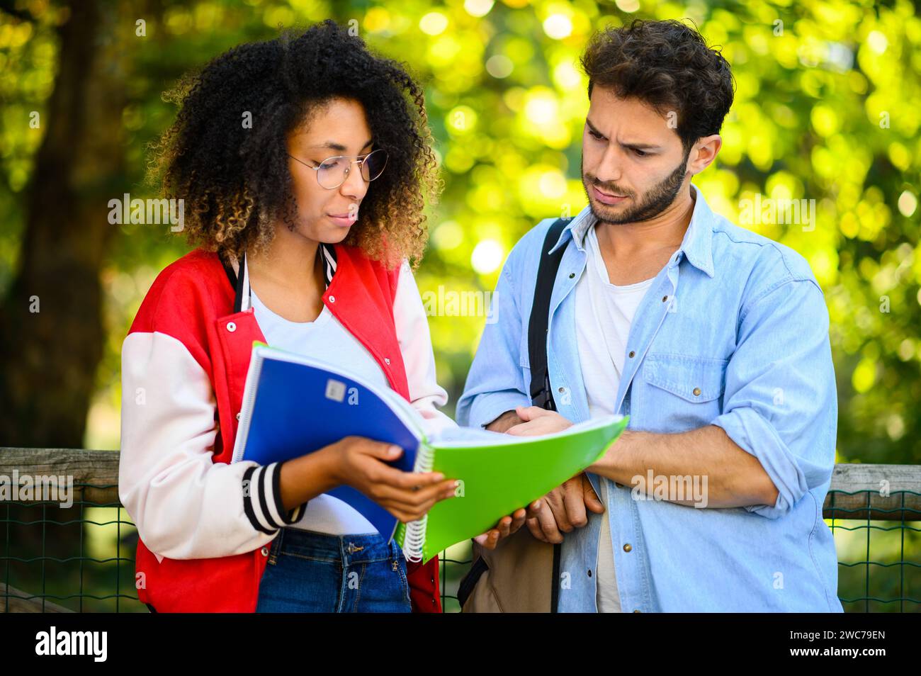 Two multiethnic students studying together outdoor Stock Photo - Alamy