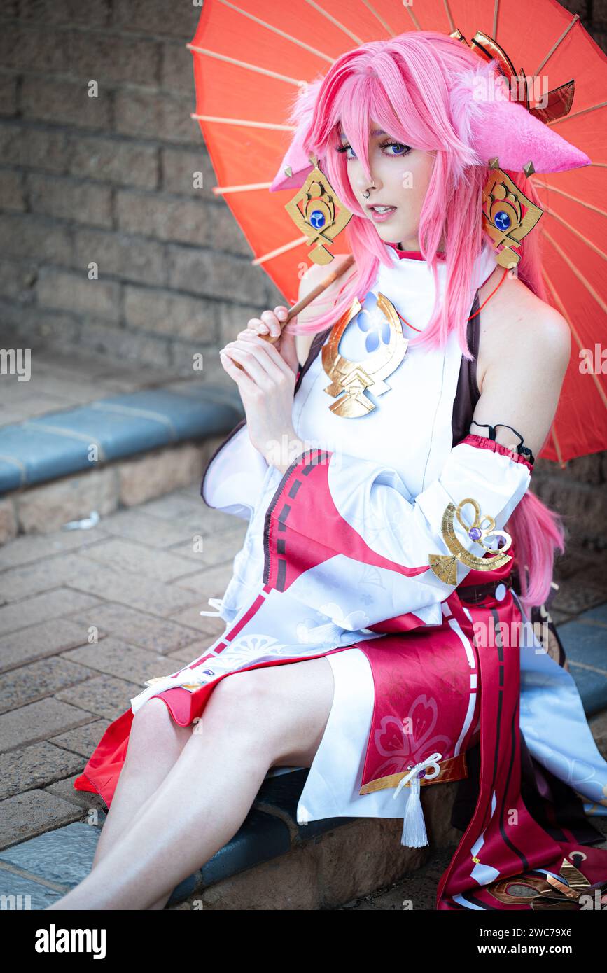 A Female cosplayer in a pink anime costume wearing pink hair Stock ...