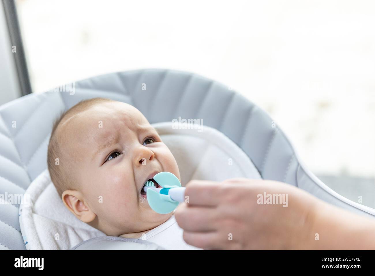 Newborn baby suffering of his tooth growth, mom using a teether to ease ...