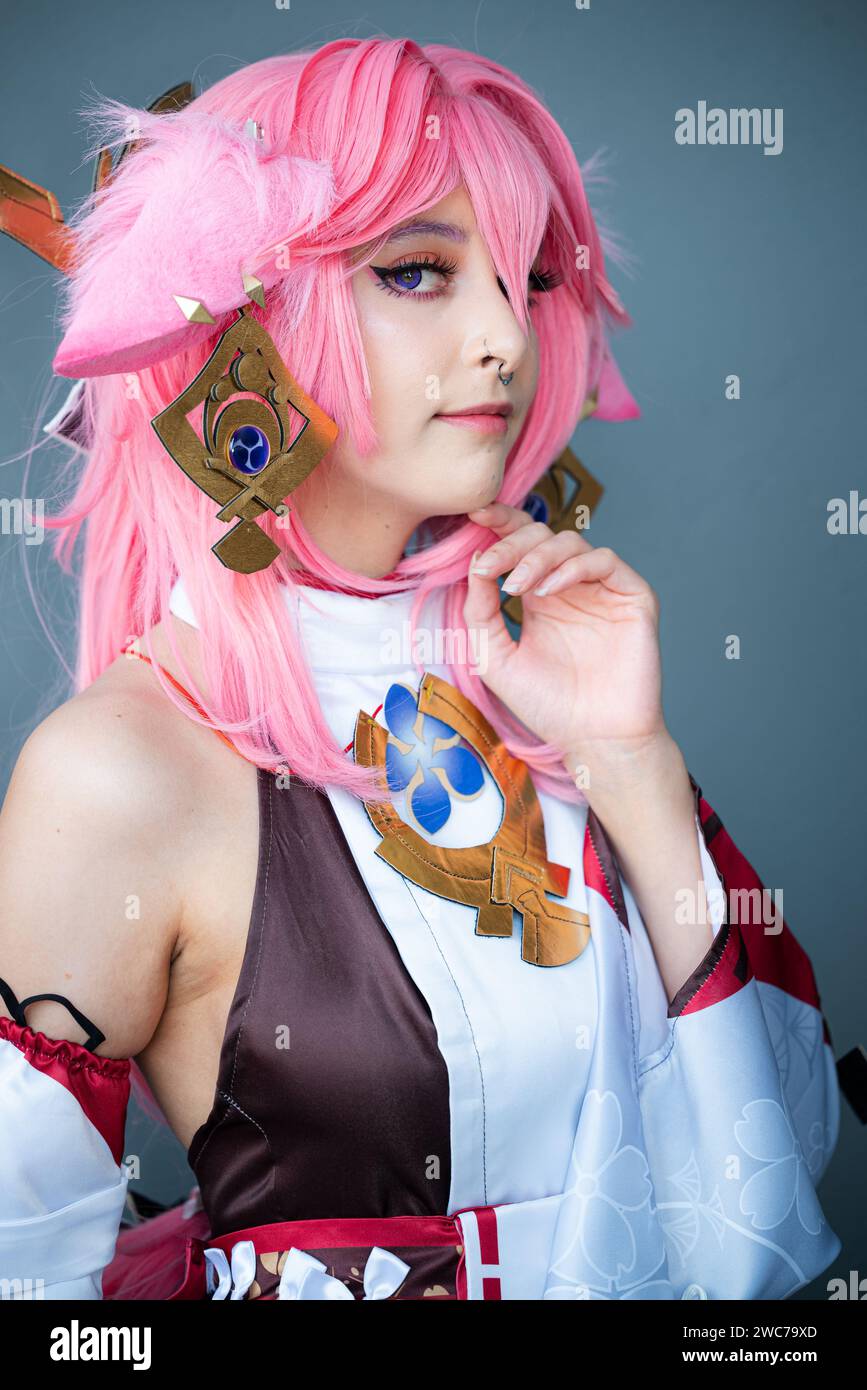A Female cosplayer in a pink anime costume wearing pink hair Stock ...