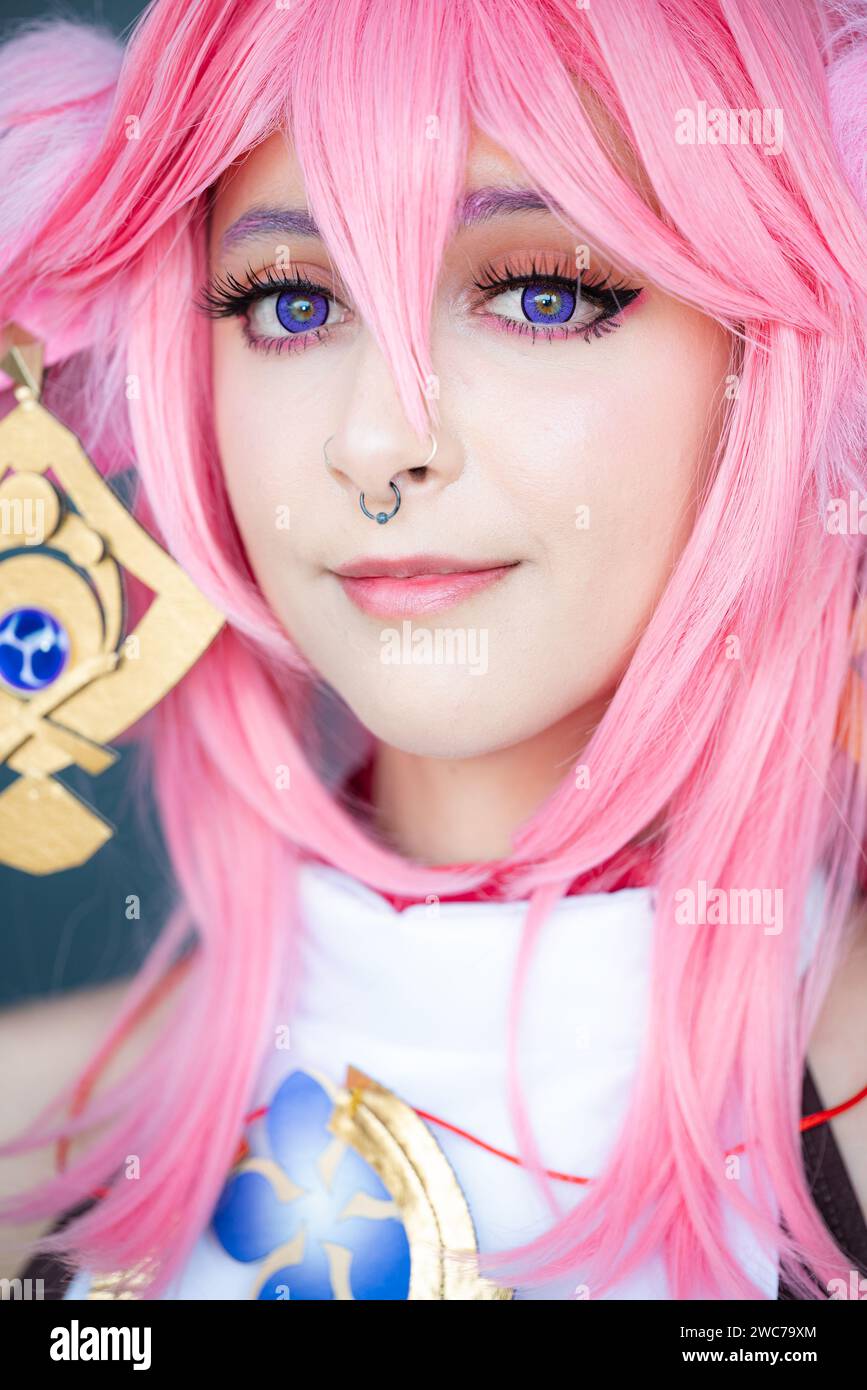 A Female cosplayer in a pink anime costume wearing pink hair Stock ...