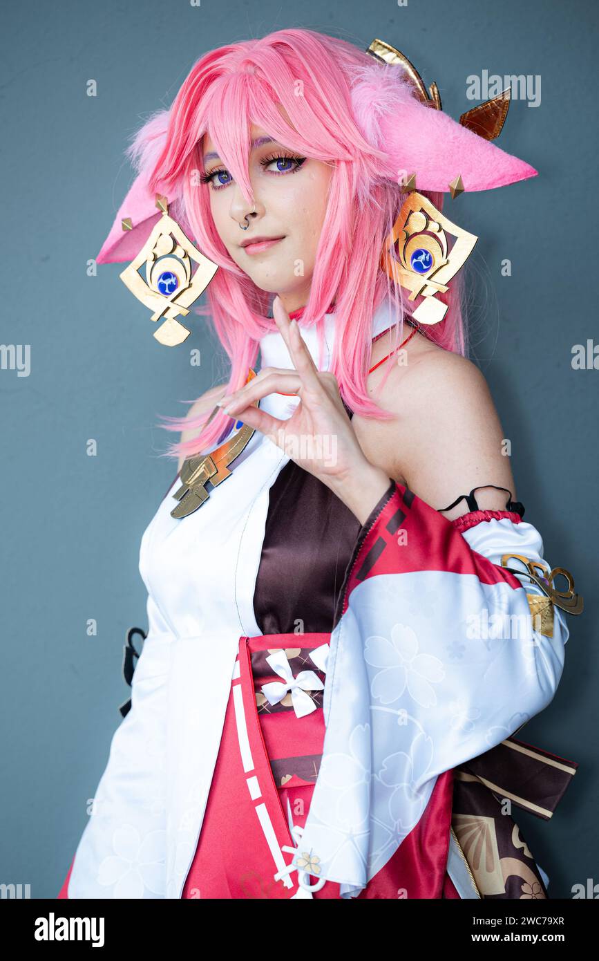 A Female cosplayer in a pink anime costume wearing pink hair Stock ...