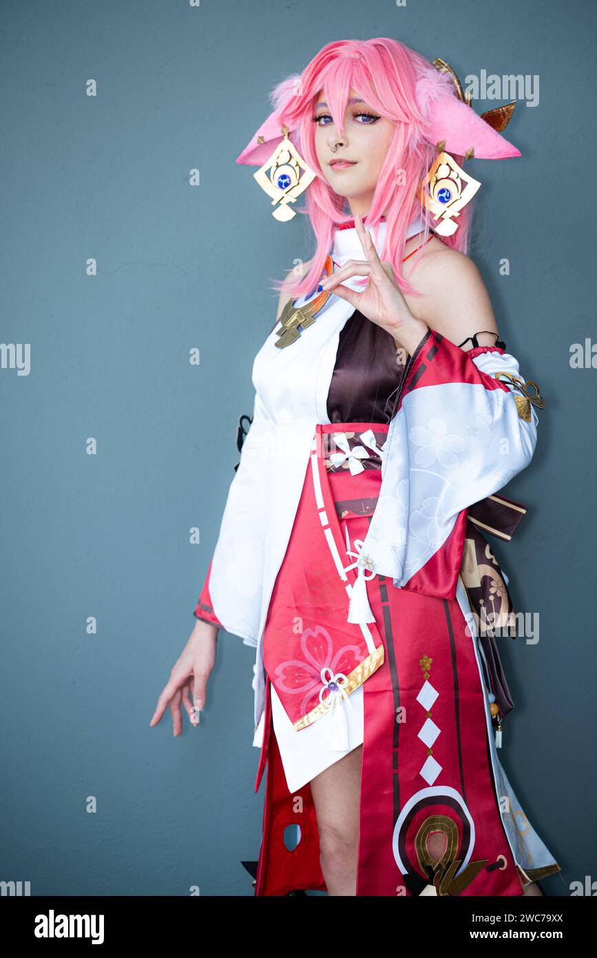 A Female cosplayer in a pink anime costume wearing pink hair Stock ...