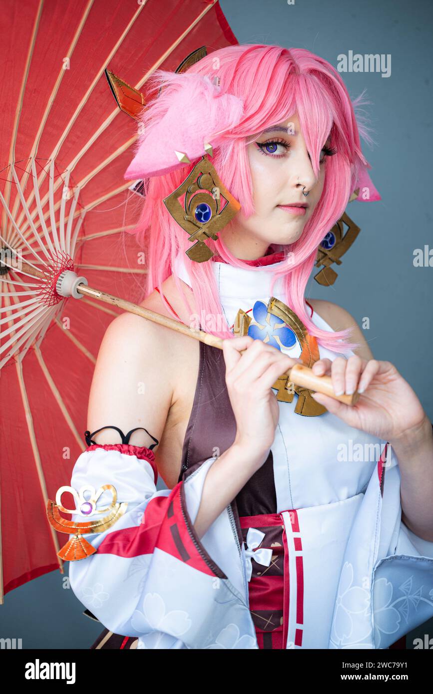 A Female cosplayer in a pink anime costume wearing pink hair Stock ...