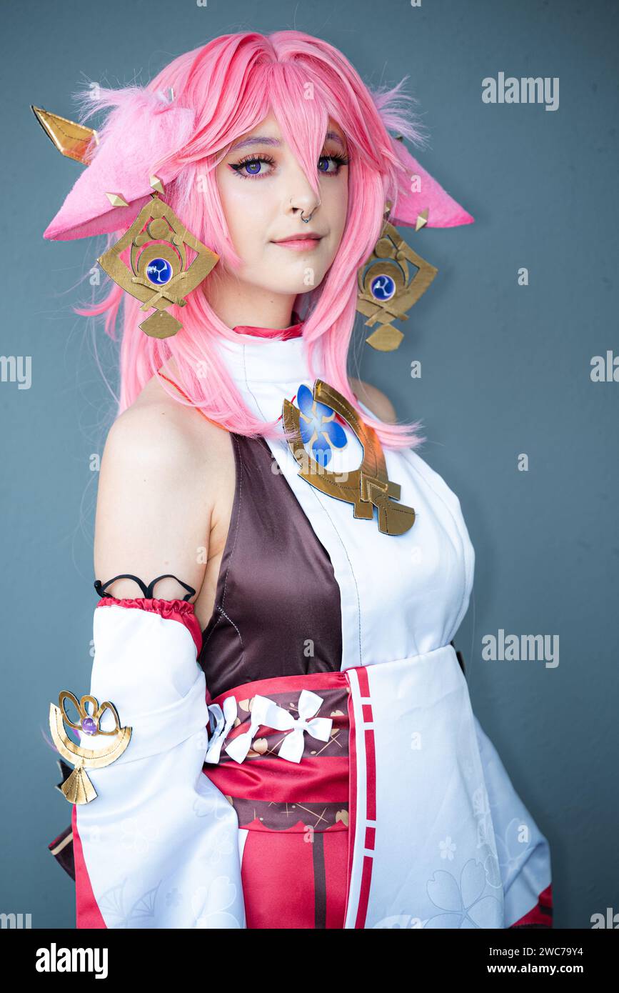 A Female cosplayer in a pink anime costume wearing pink hair Stock ...
